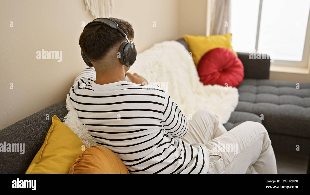 Attractive young hispanic man engrossed in sonic world, relaxing and ...