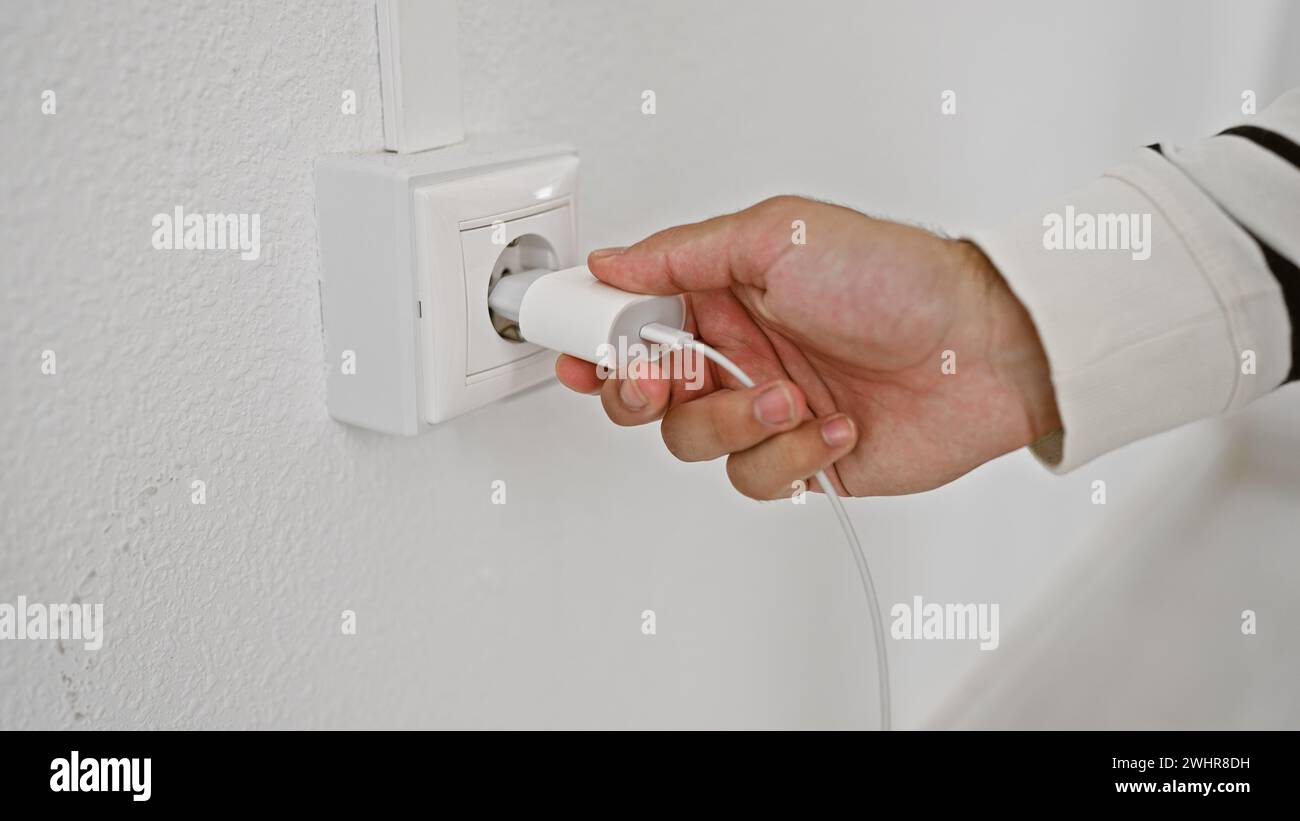 Hispanic man's hands charging energy at home, powering his tech via an ...