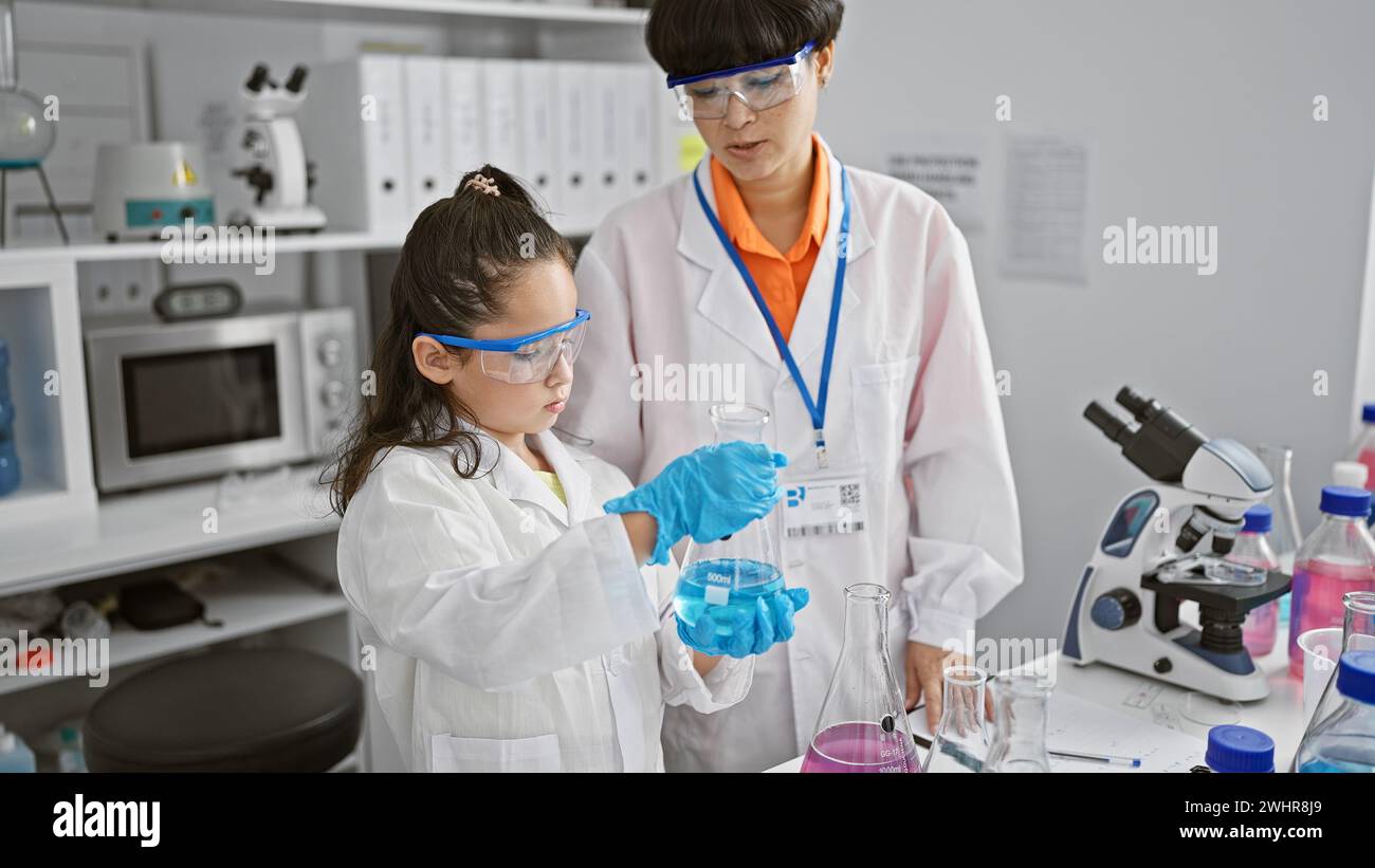 Two dedicated scientists, working intensely together in a laboratory ...