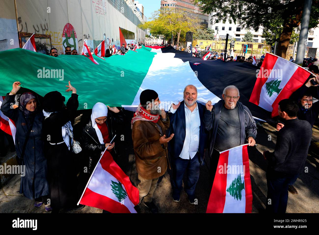 Demonstrators hold a giant Palestinian flag and Lebanese flags during a ...