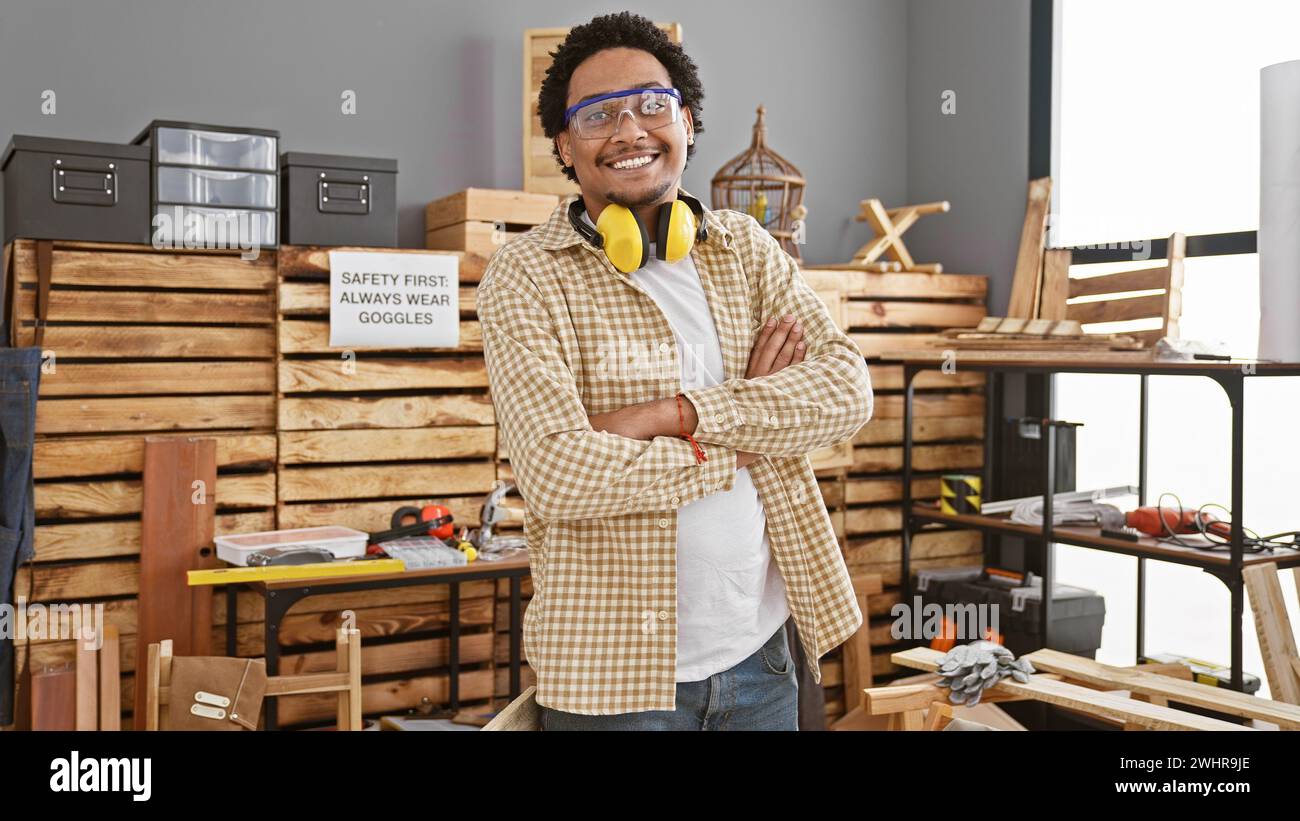 Confident young man with crossed arms wearing safety goggles and ...