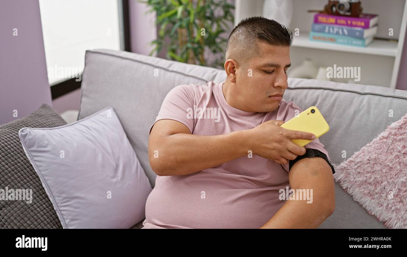 Confident latin guy, scanning his diabetes sensor with phone ...