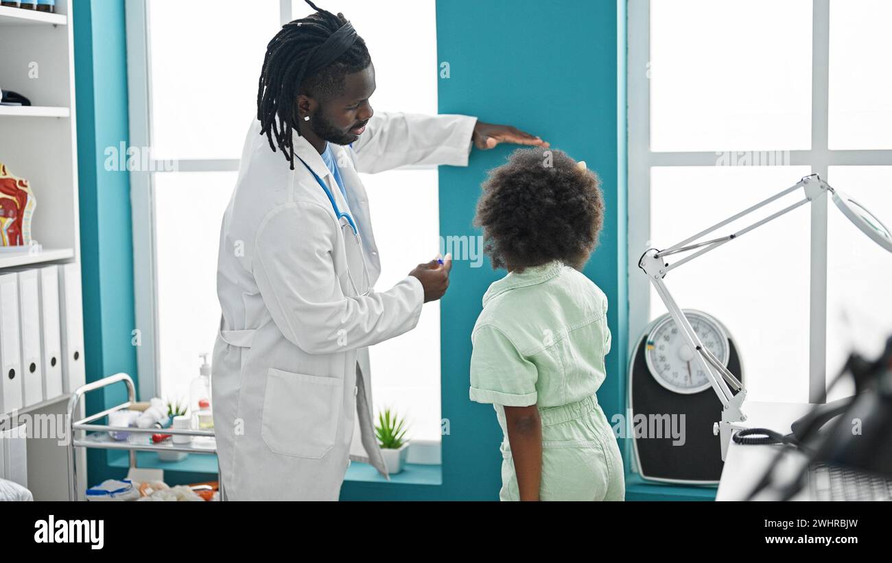 Doctor and patient having medical consultation measuring height at the ...