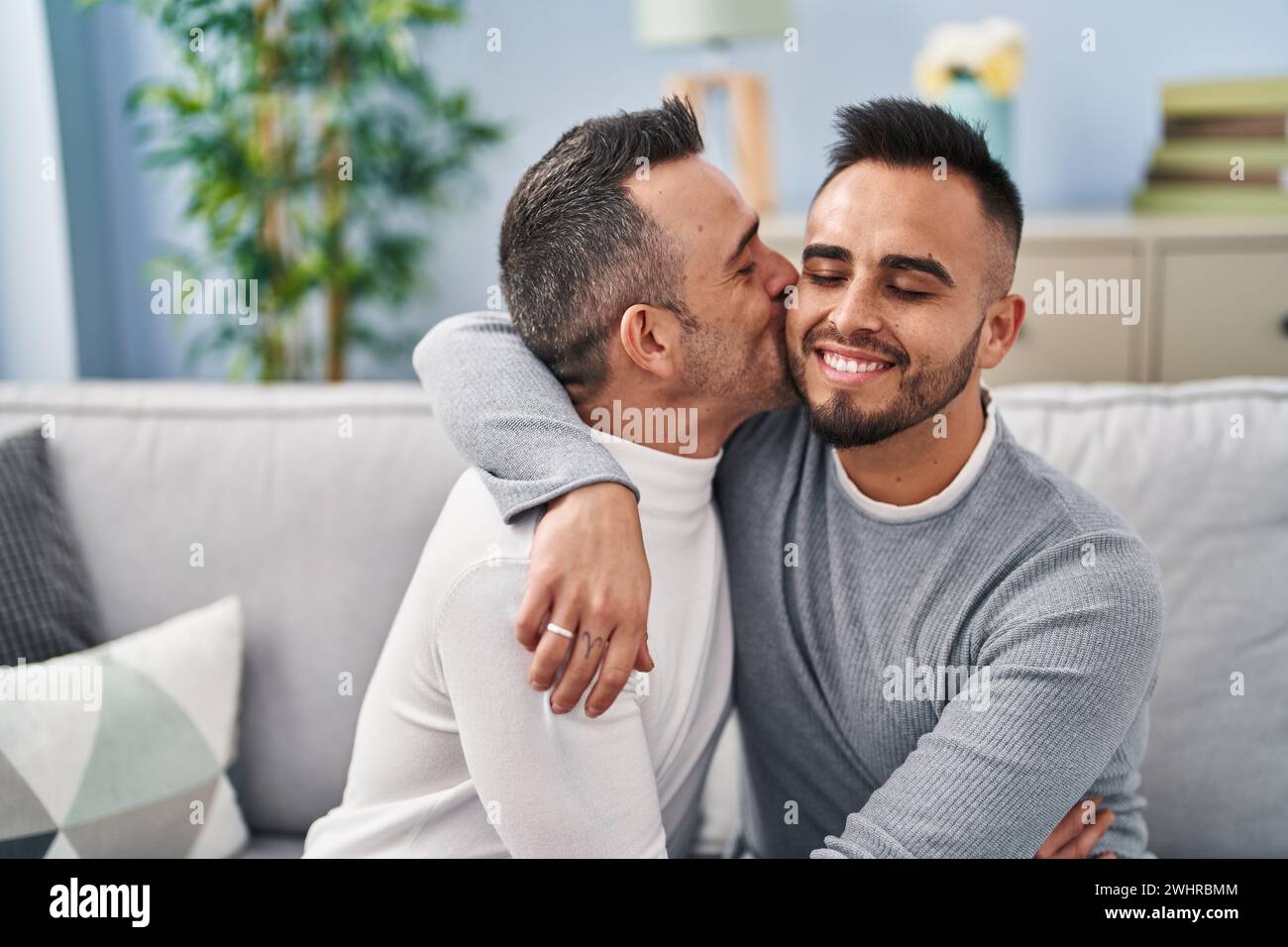Two men couple hugging each other kissing at home Stock Photo - Alamy