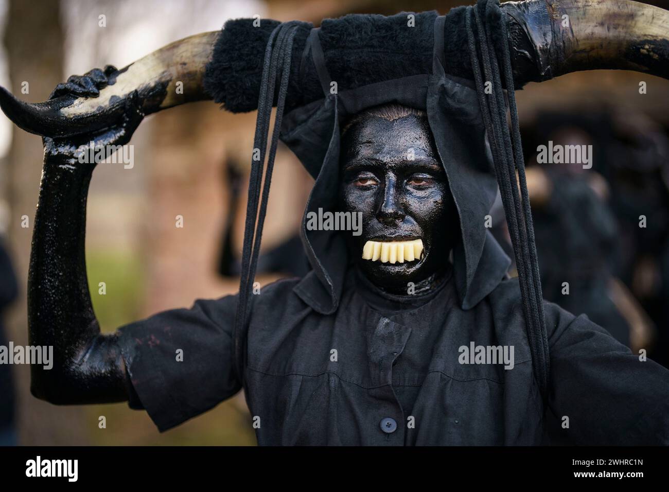 A woman dressed to represent the devil dons bull horns with her face ...