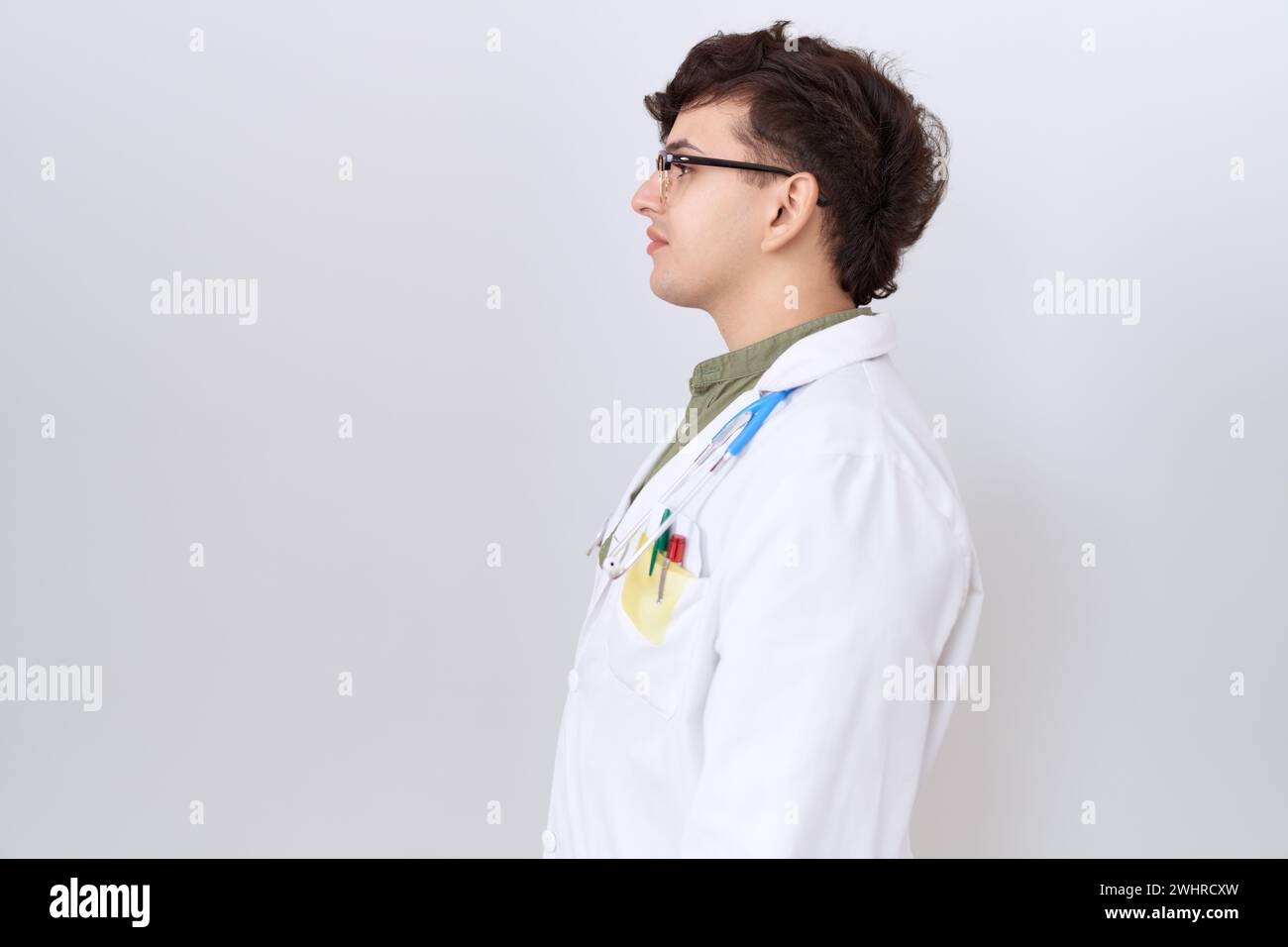 Young non binary man wearing doctor uniform and stethoscope looking to ...