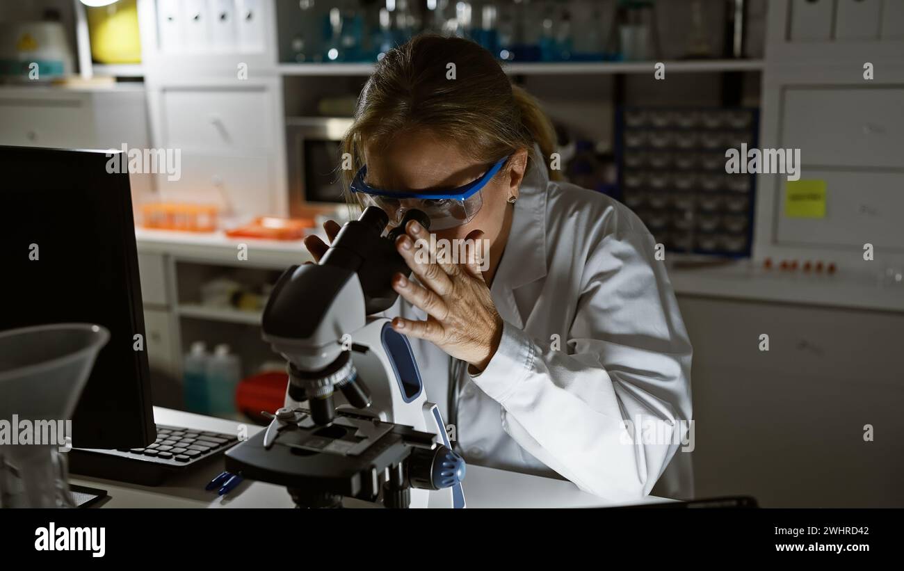 Woman examines samples under microscope hi-res stock photography and ...