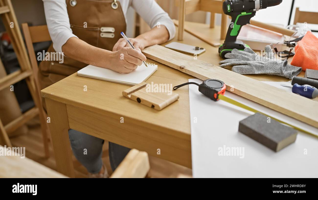 A middle-aged woman sketches in a carpentry workshop surrounded by ...