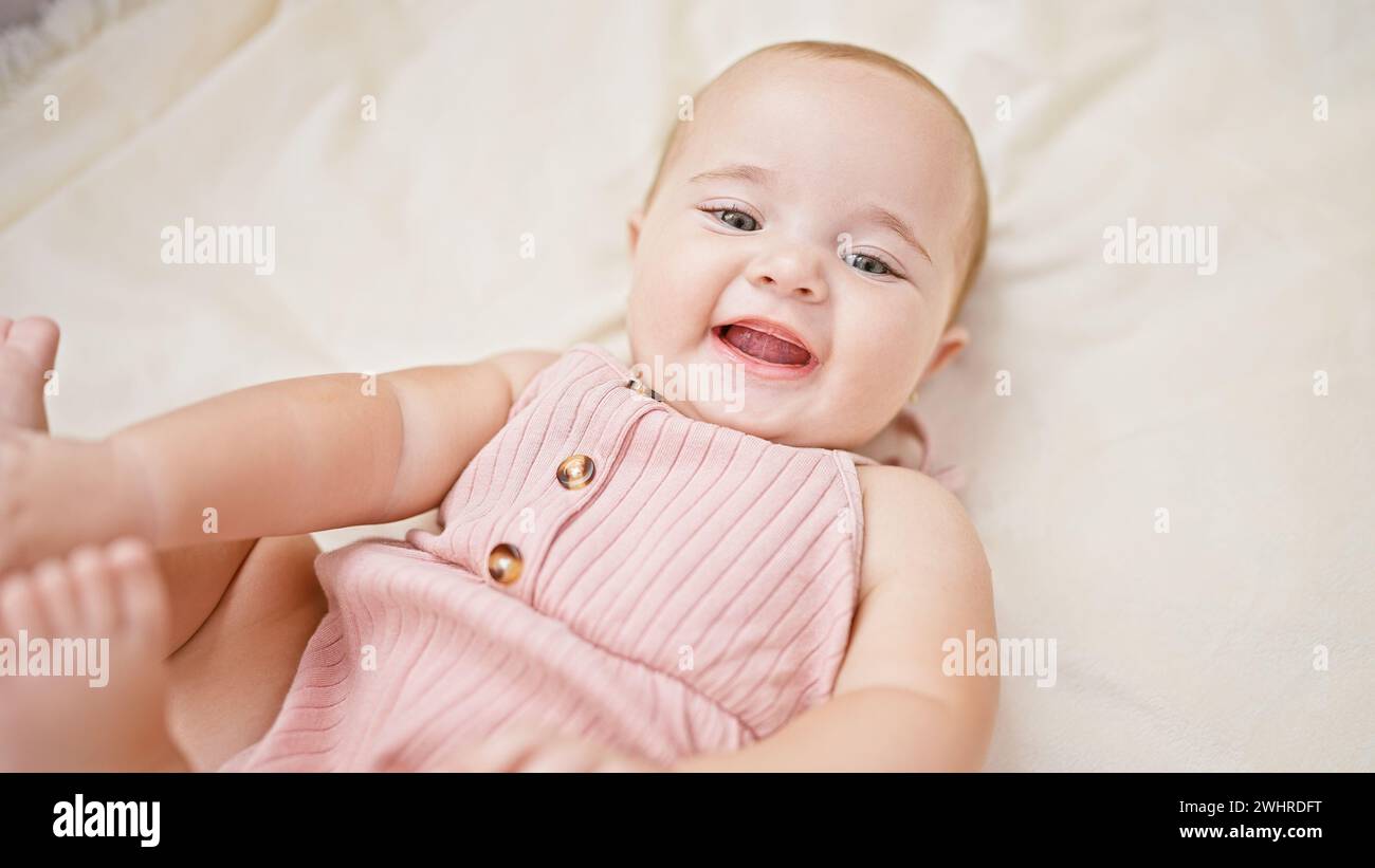 Adorable little baby, all relaxed and comfy, cutely lying on sofa ...