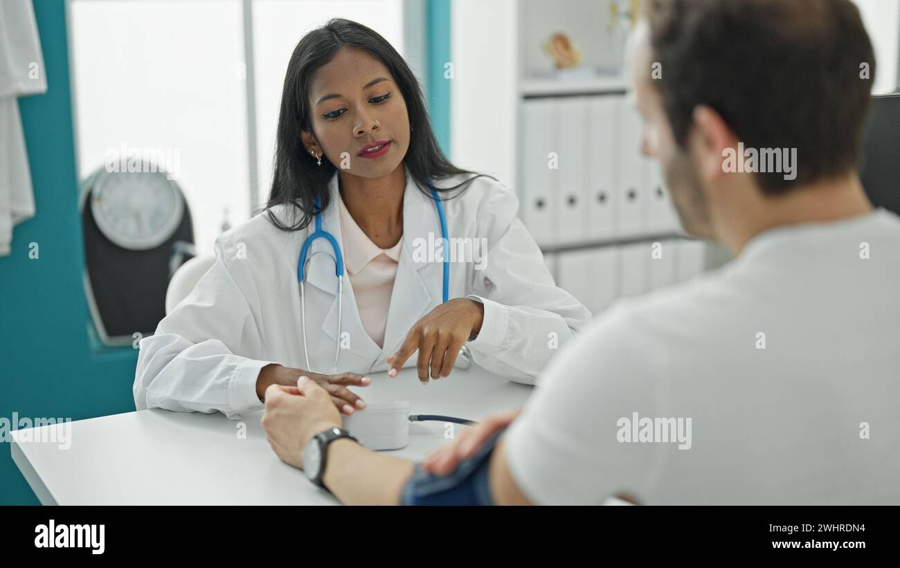 Doctor and patient sitting on table measuring pulse using tensiometer ...