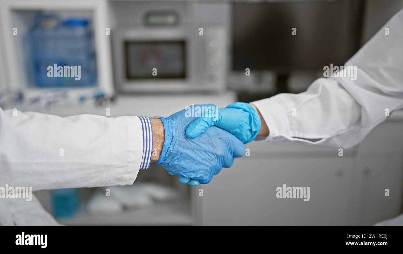 Scientists shaking hands in lab hi-res stock photography and images - Alamy