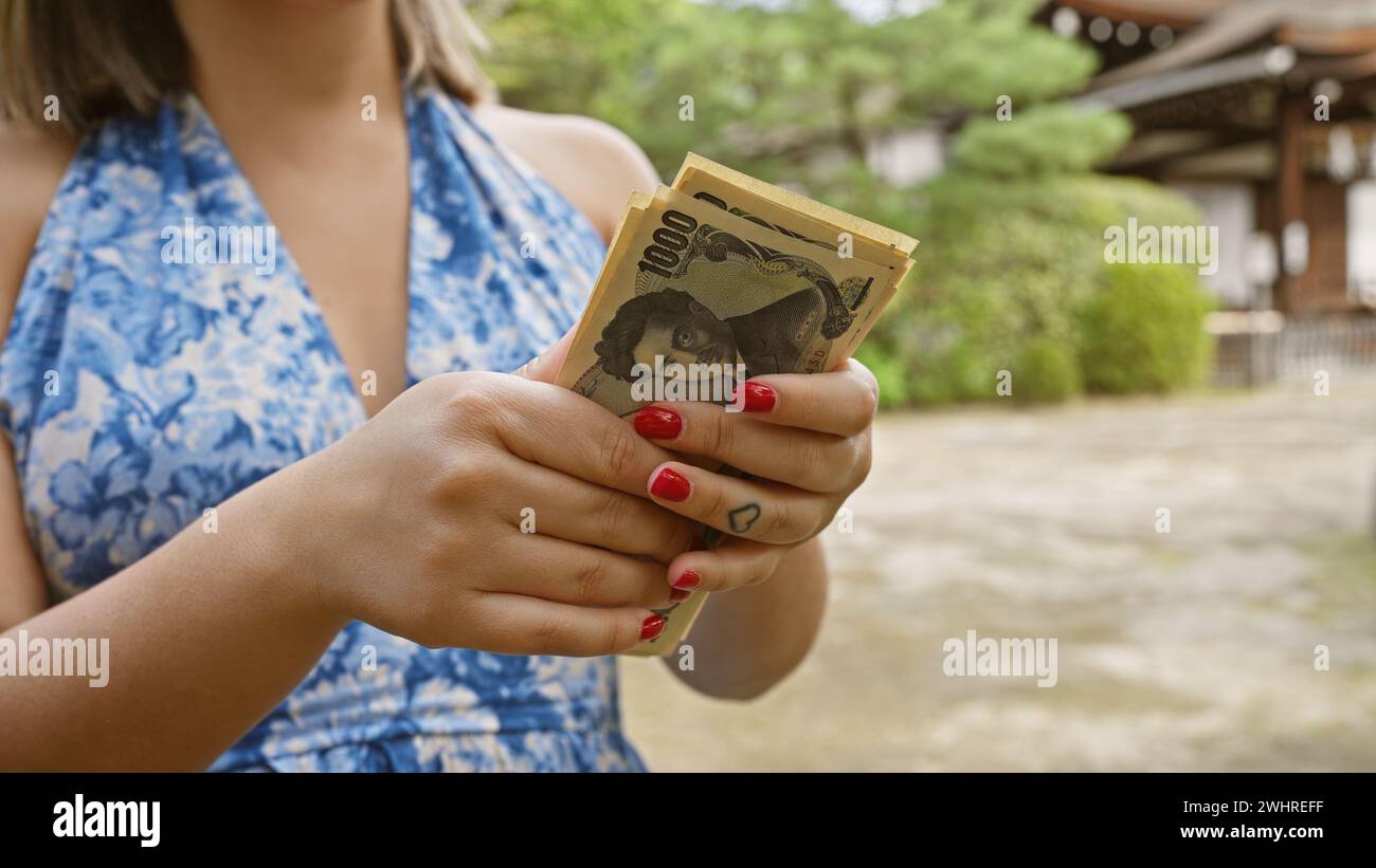 Caucasian young woman's hands counting wealth of japan yen banknotes at ...