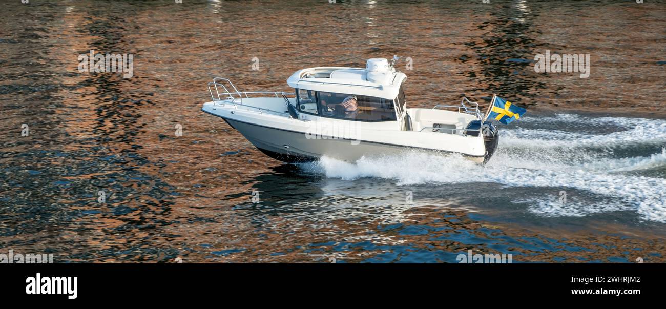 Speedboat in Swedish flag sailing in colorful from sunbeam sea ...