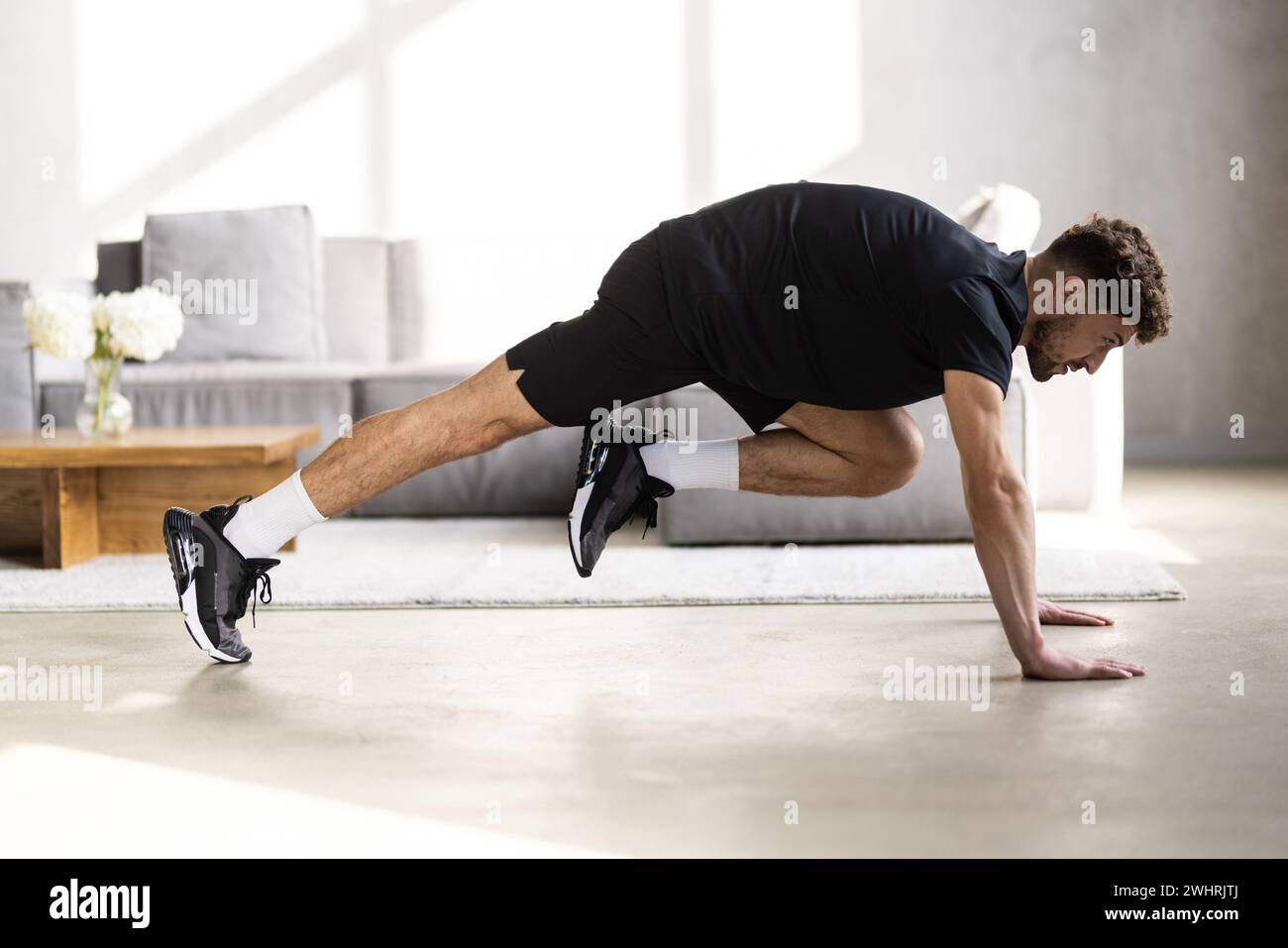 Sporty young guy doing flexibility exercises at home, banner Stock ...