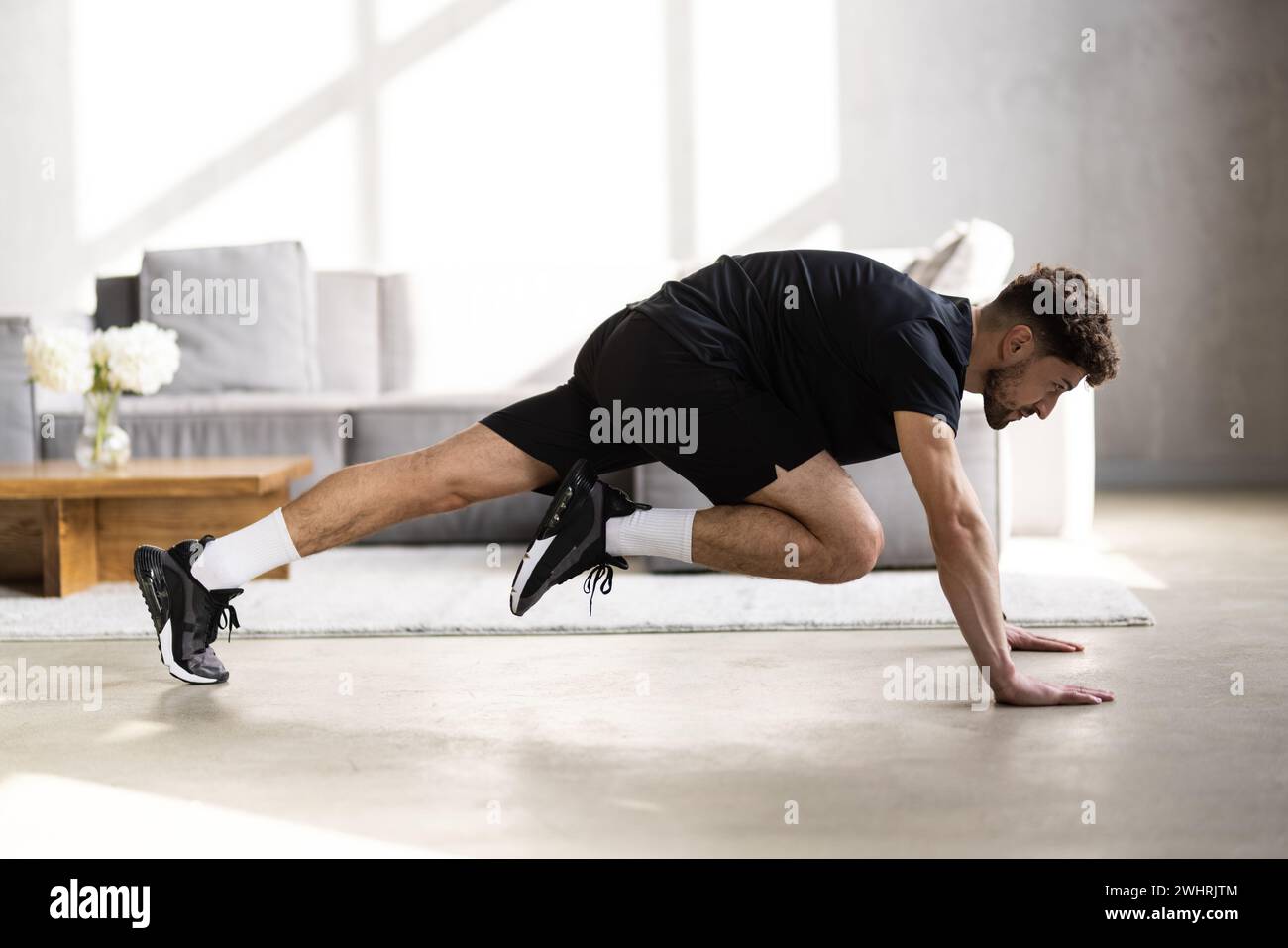 Sporty young guy doing flexibility exercises at home, banner Stock ...