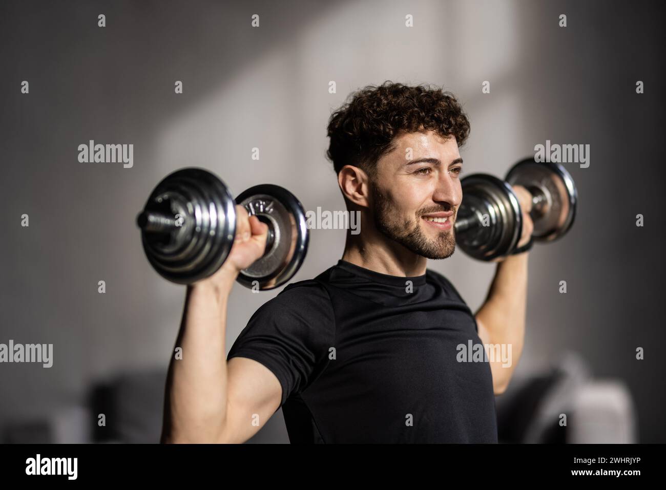 Closeup of handsome middle-aged man doing dumbbell workout at home ...