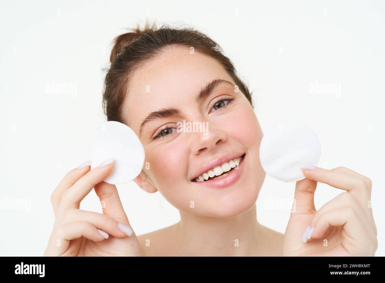 Portrait of young woman cleansing her face, takes off her makeup ...