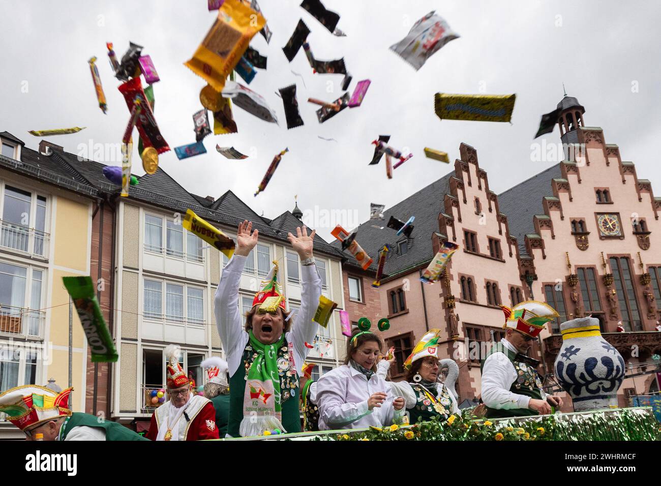 11 February 2024, Hesse, Frankfurt/Main: Fools throw sweets from a ...