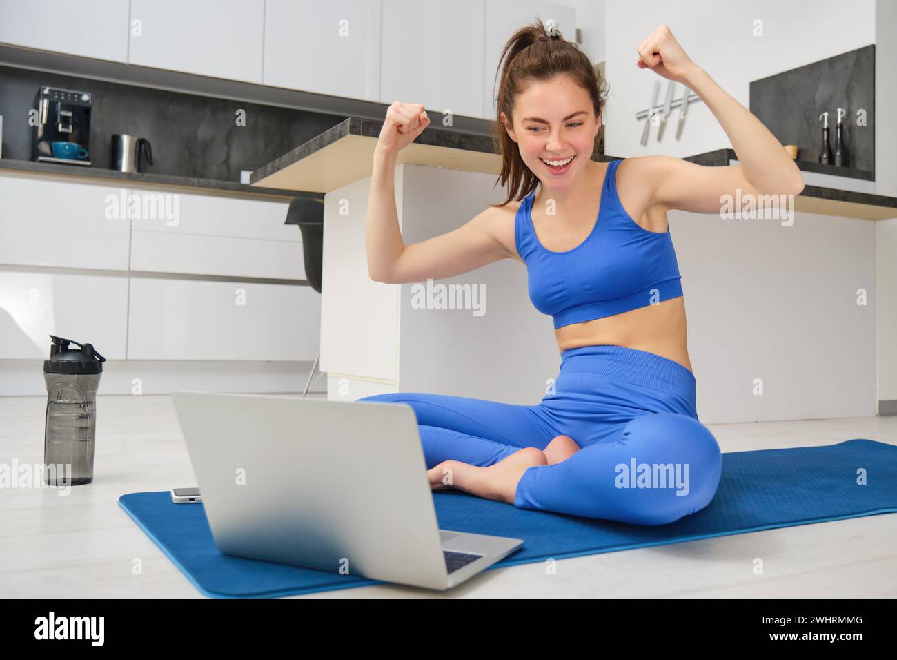 Image of excited young woman showing muscles, flexing biceps and ...