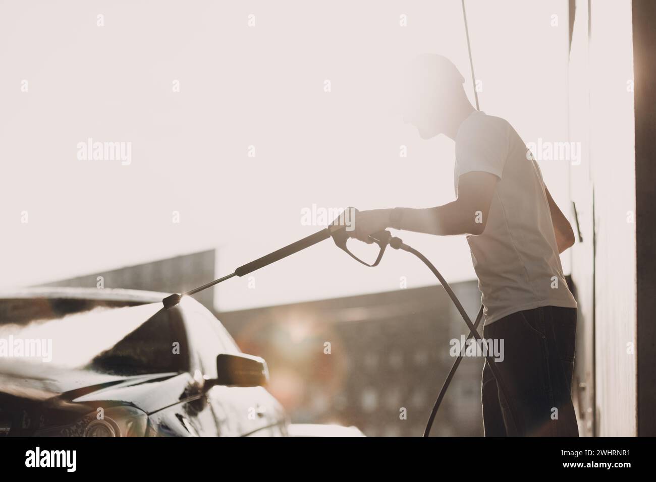 Worker washing car at self-service car wash Stock Photo - Alamy