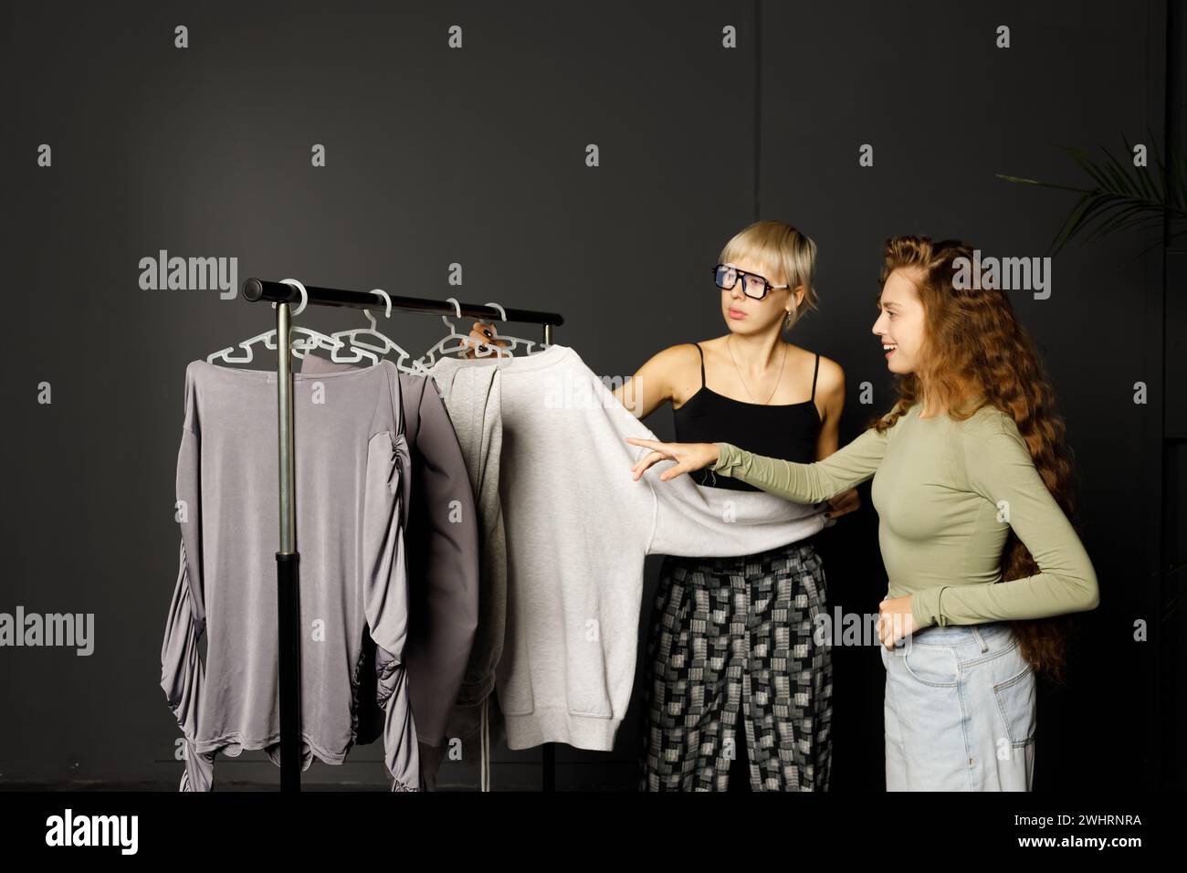 Stylist designer helping choose clothes dress to customer client Stock ...