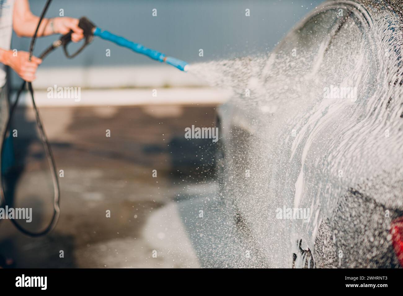Worker washing car at self-service car wash Stock Photo - Alamy