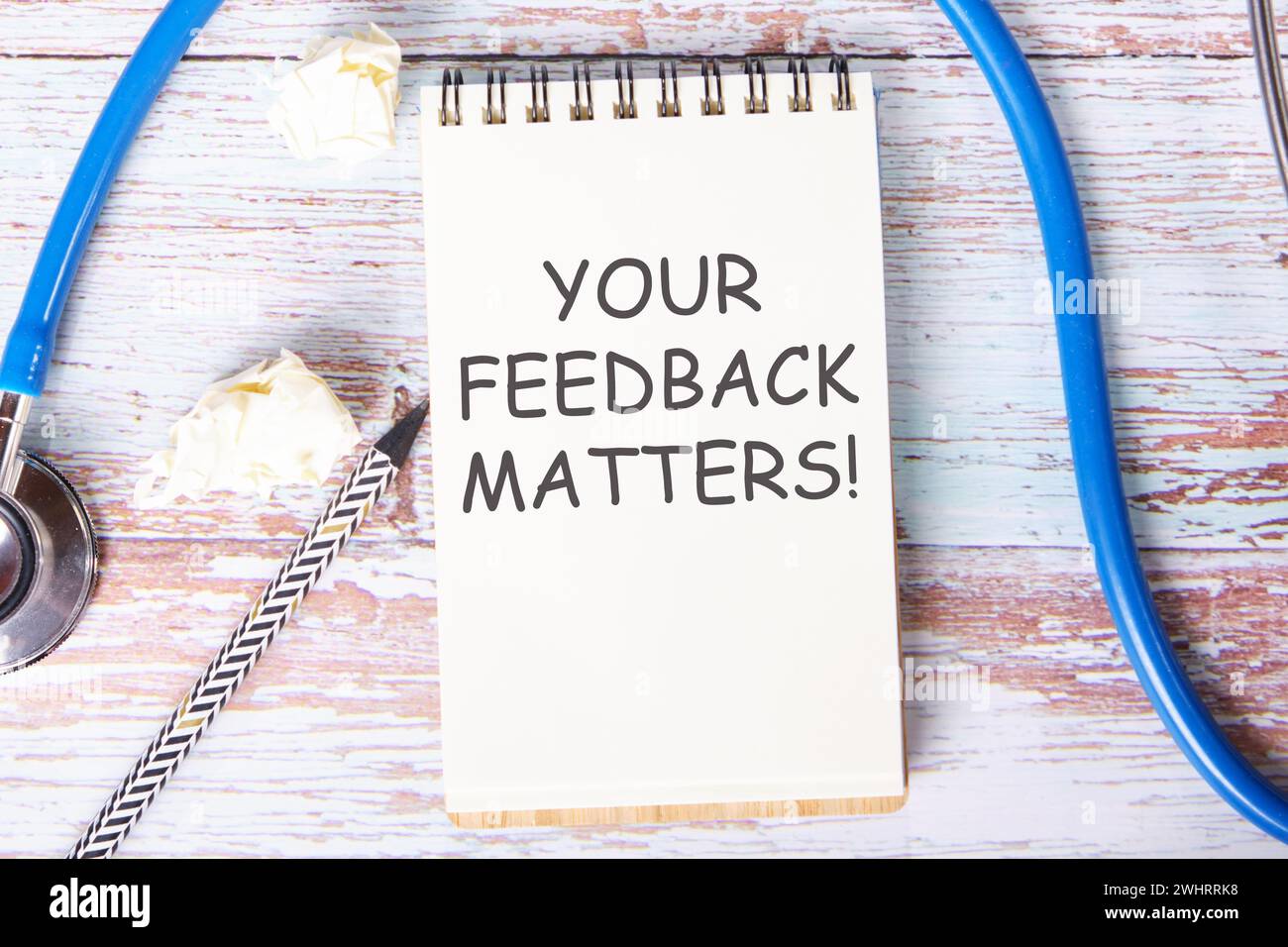 YOUR FEEDBACK MATTERS text is written on a notebook that lies on old ...