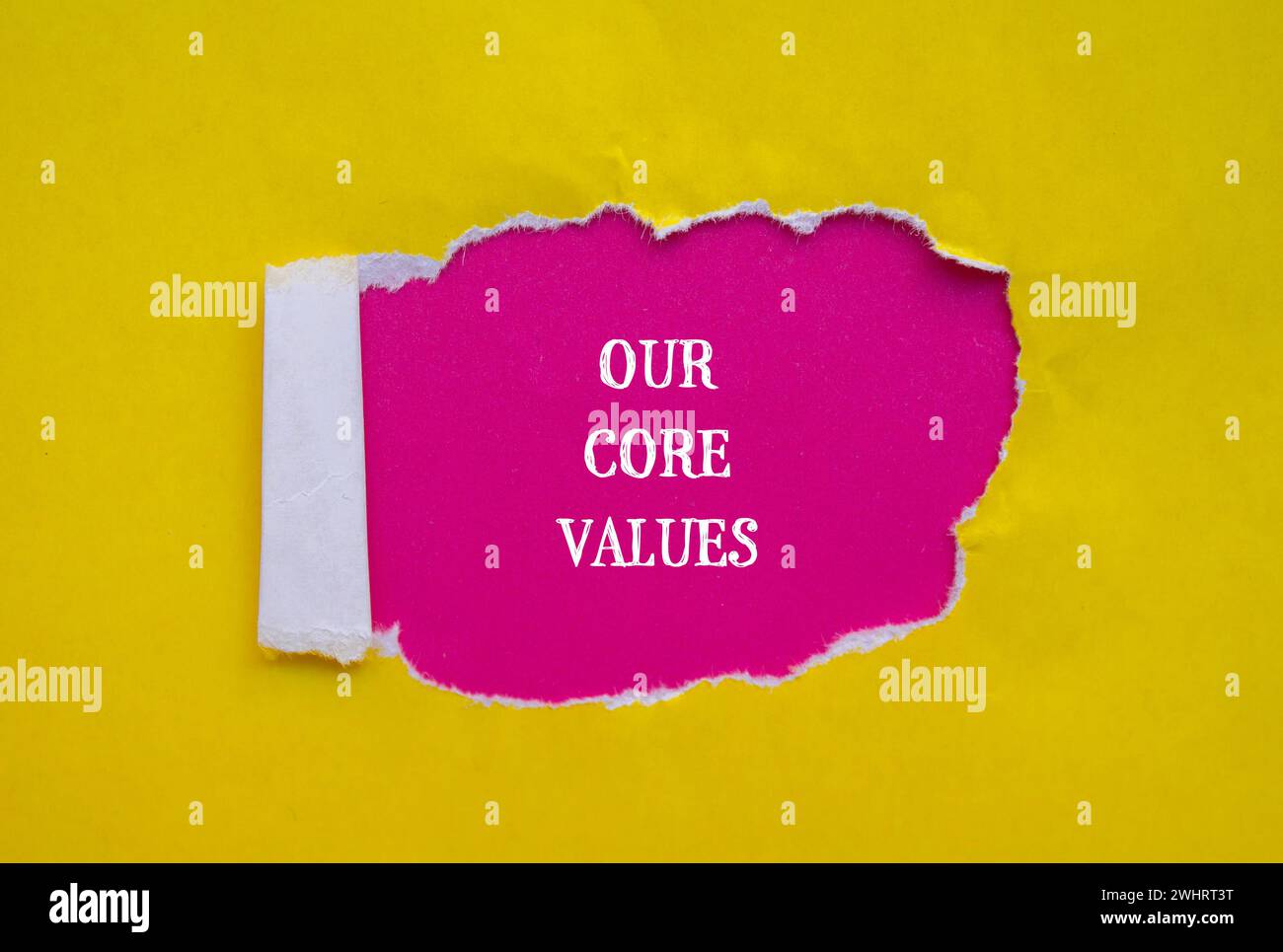 Our core values words written on yellow torn paper with pink background ...