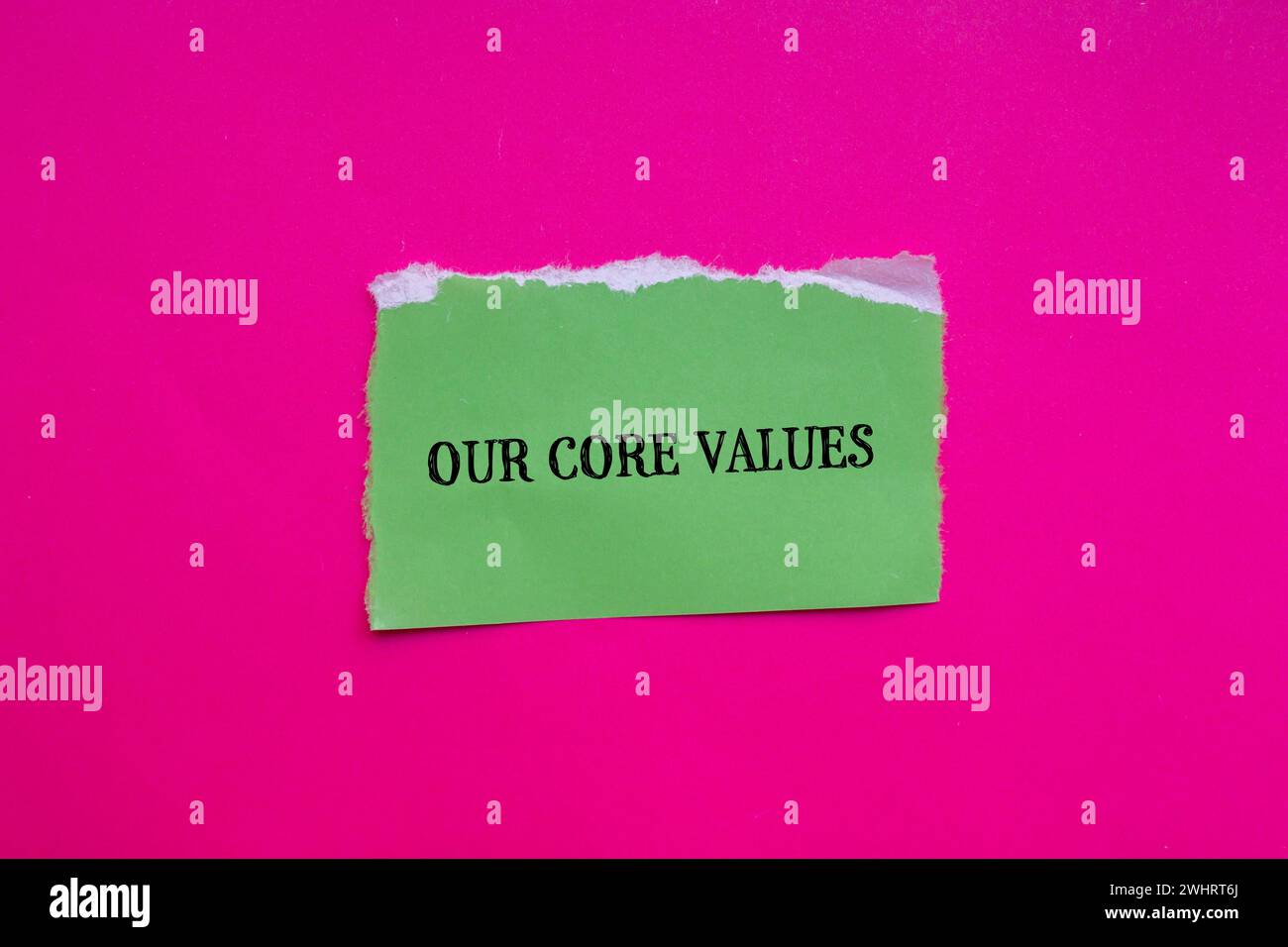 Our core values words written on green torn paper piece with pink background. Conceptual ...