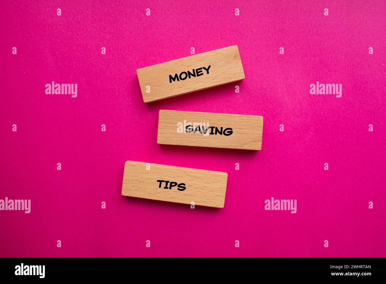 Money saving tips lettering on wooden blocks with pink background ...