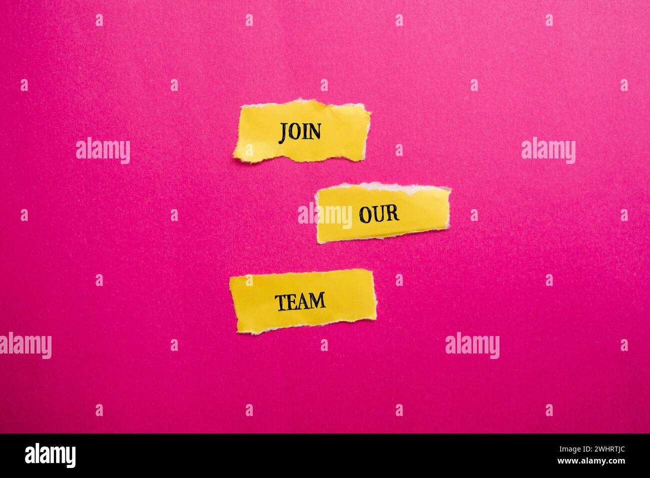 Join our team words written on yellow torn paper pieces with pink ...