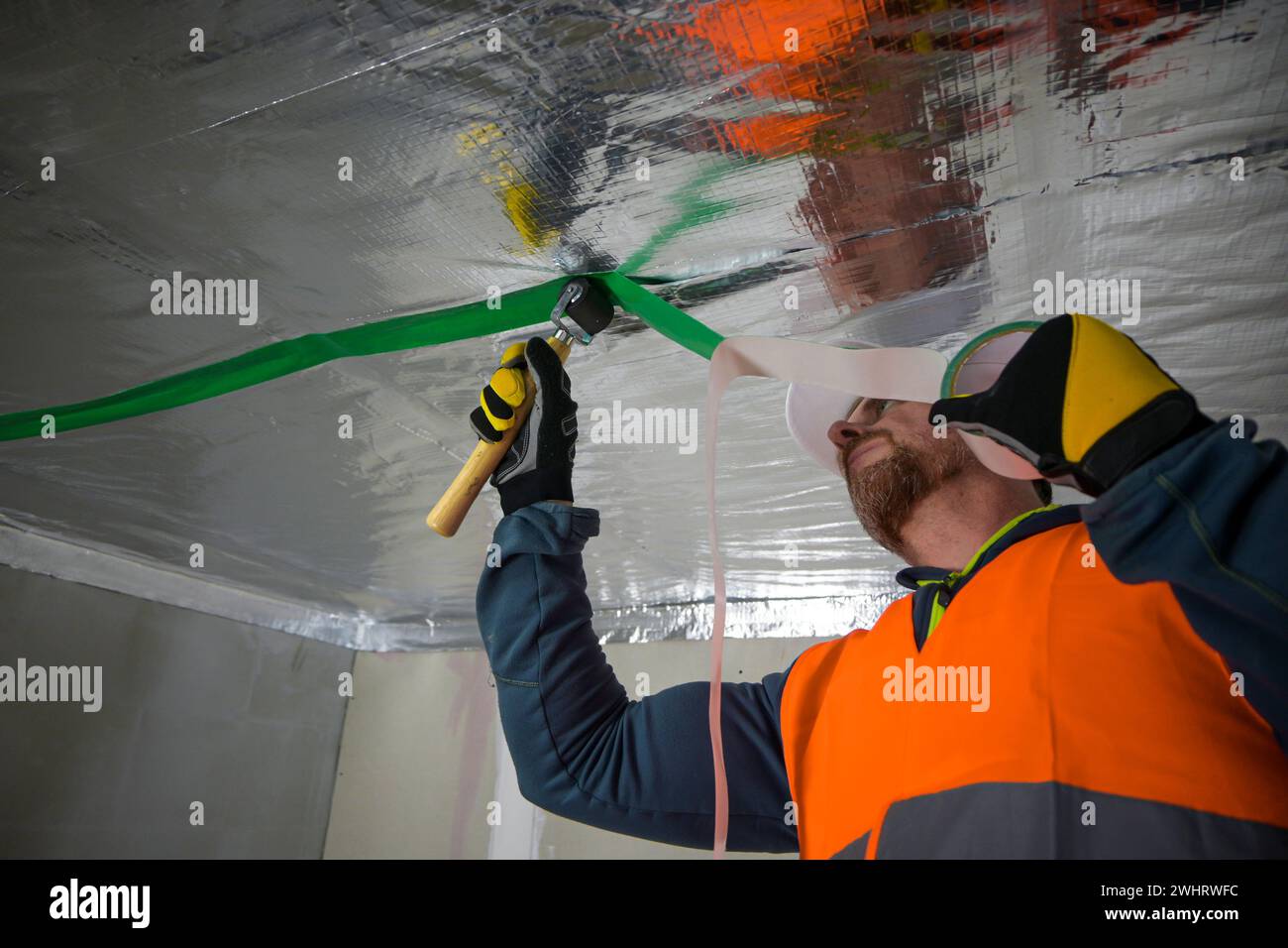 the construction worker uses aluminum tape and they had a roller for ...