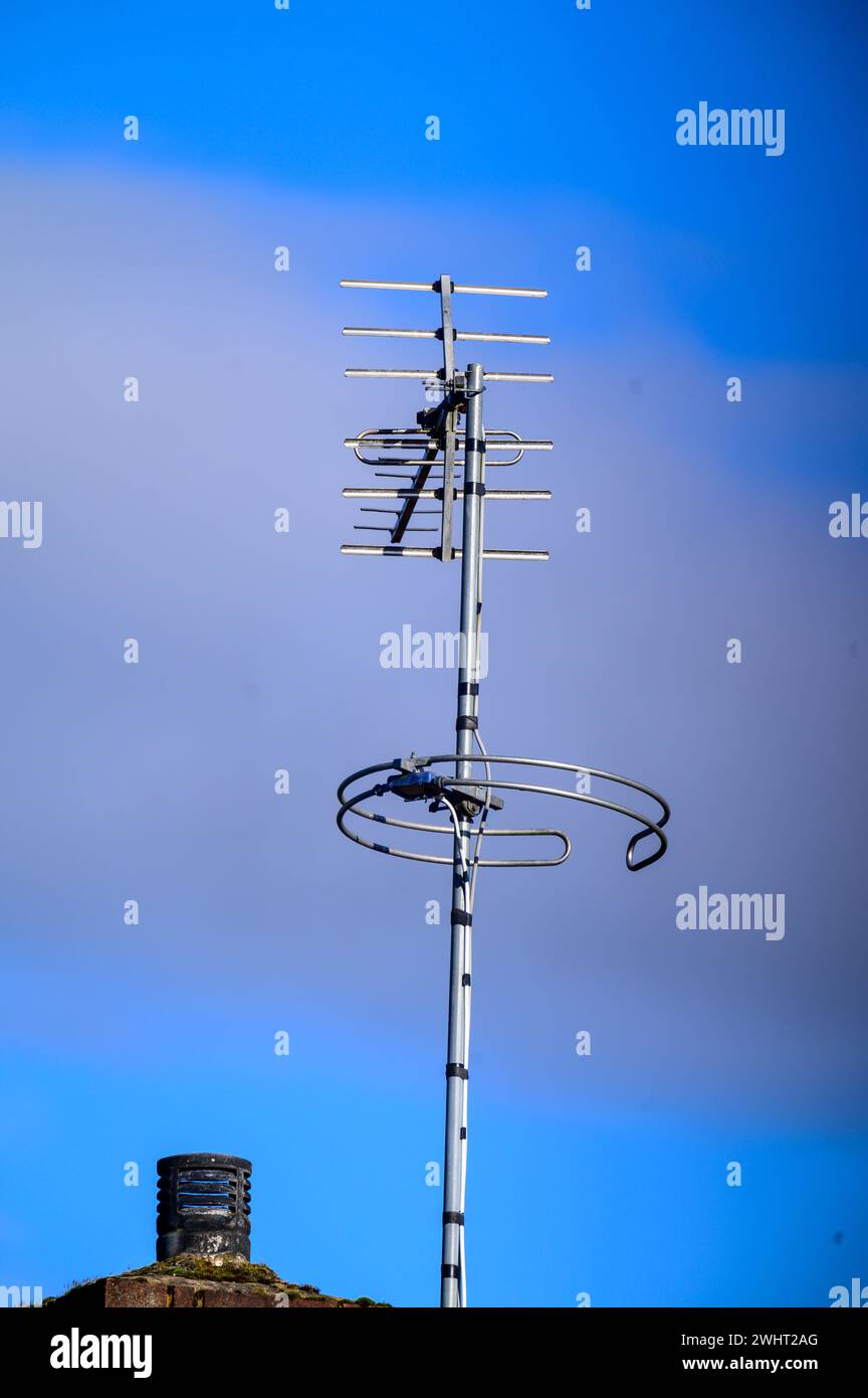 Aluminium Tv and radio aerial on the roof of a propert seen against a ...