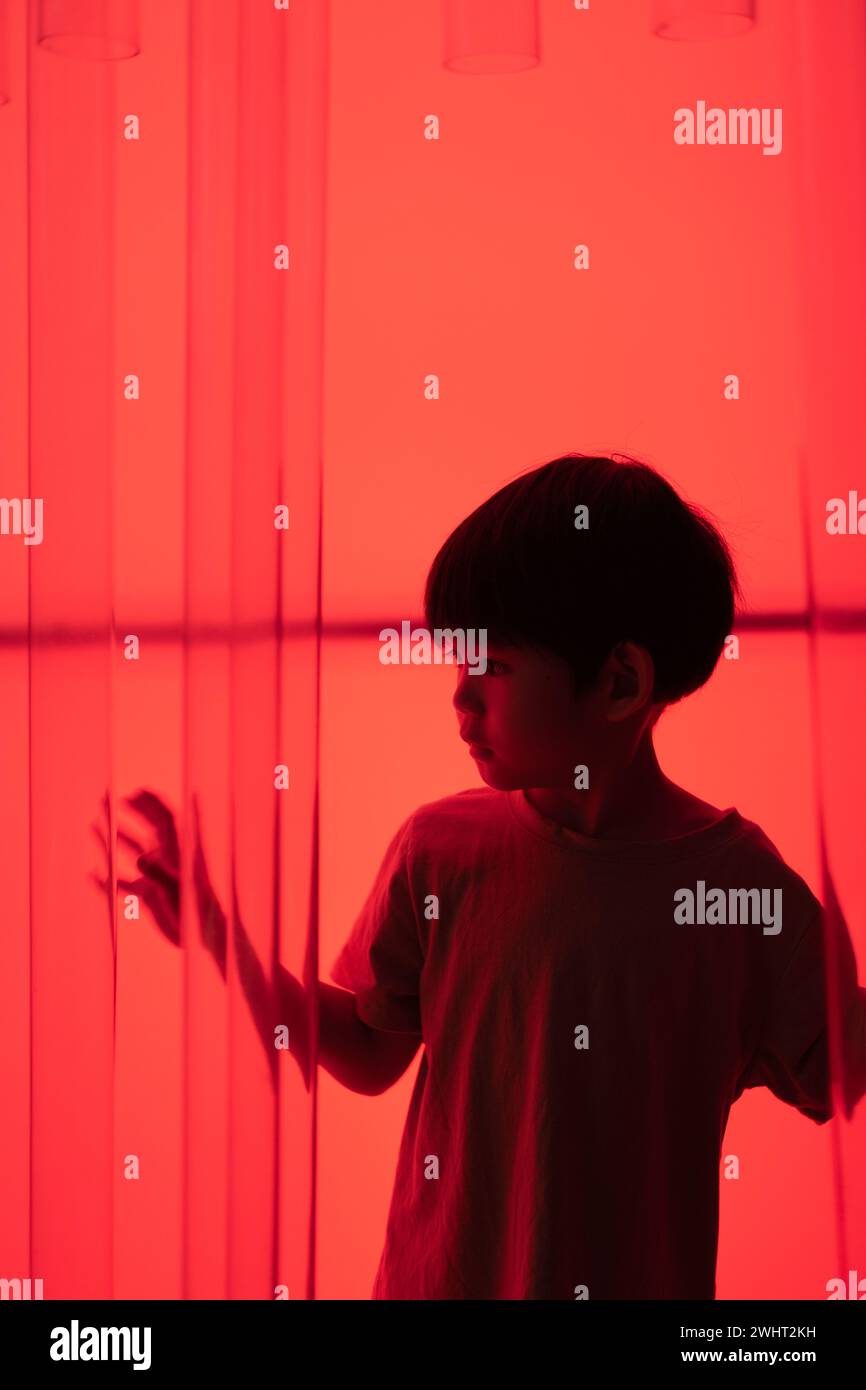 Little Asian boy, dark red background Stock Photo - Alamy