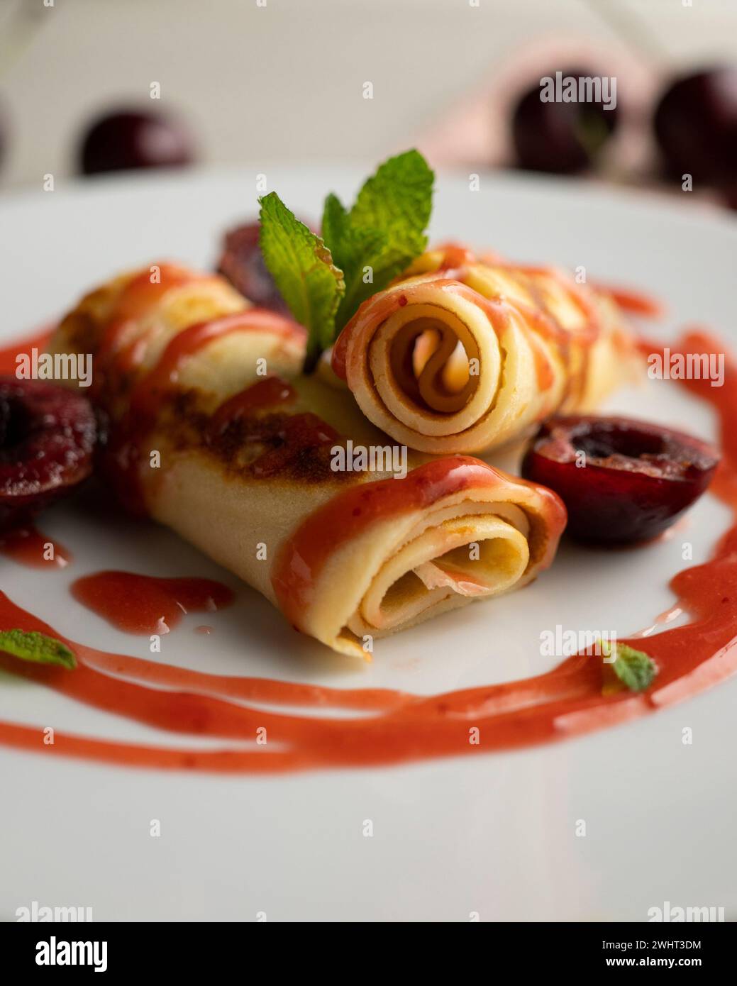 Delicious French crepes with fresh cherries and red fruit syrup Stock ...