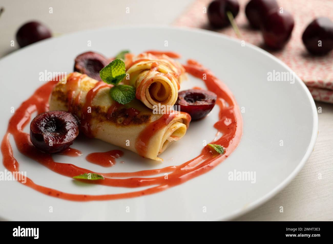 Delicious French crepes with fresh cherries and red fruit syrup Stock ...