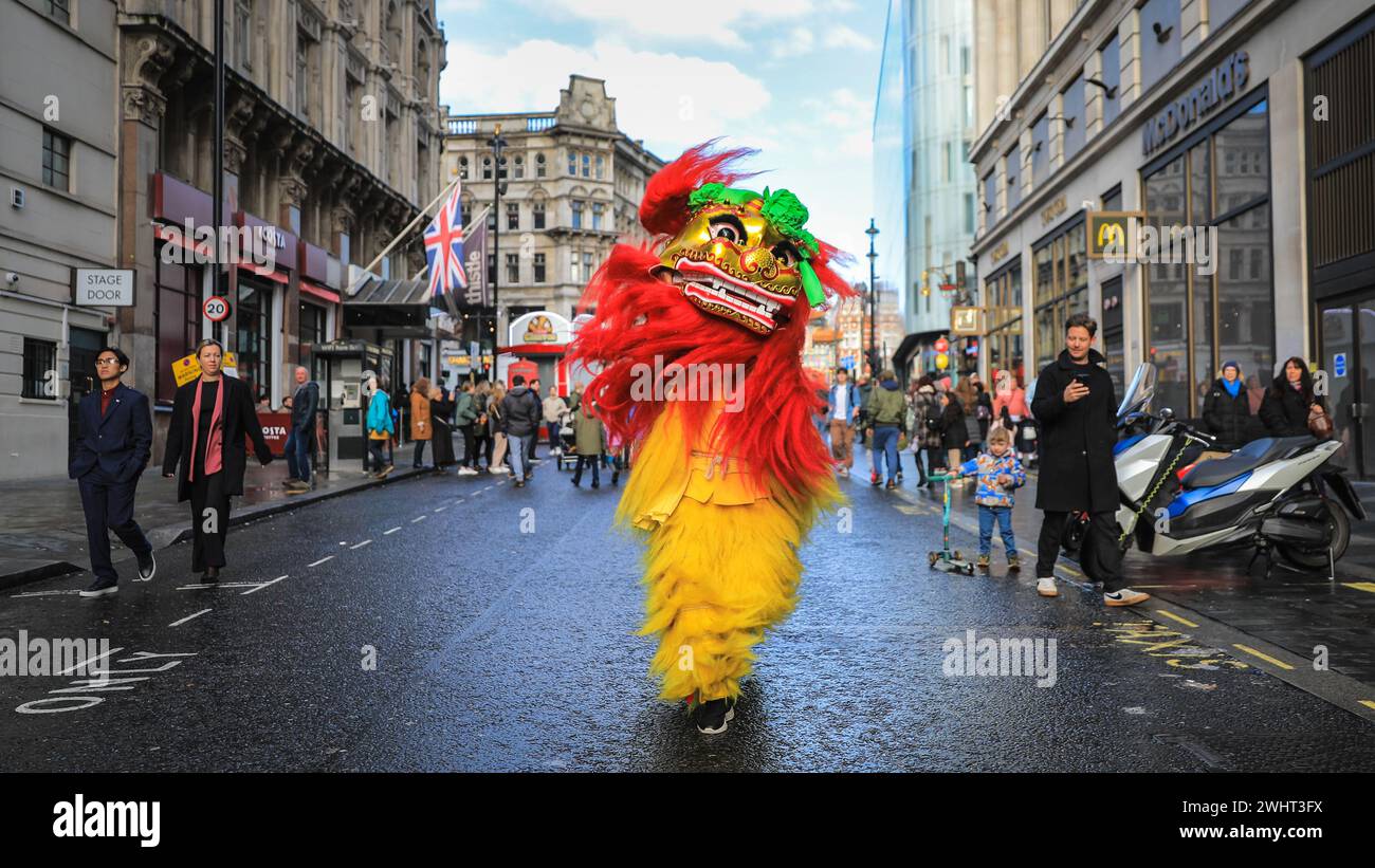 London, UK. 11th Feb, 2024. Two lion dancers run down the road in Soho ...