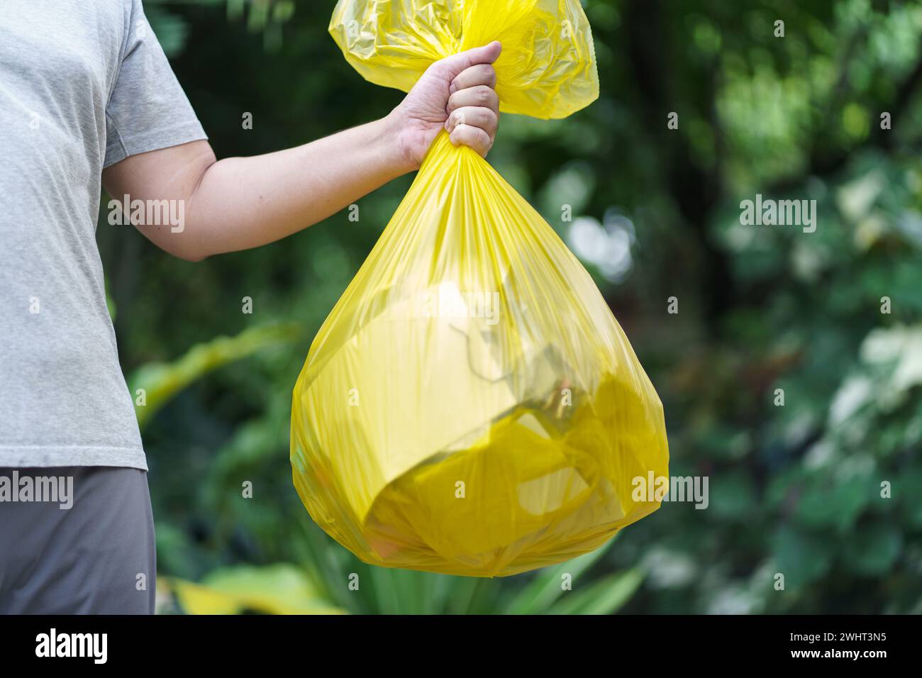 Man Volunteer charity holding garbage yellow bag and plastic bottle ...