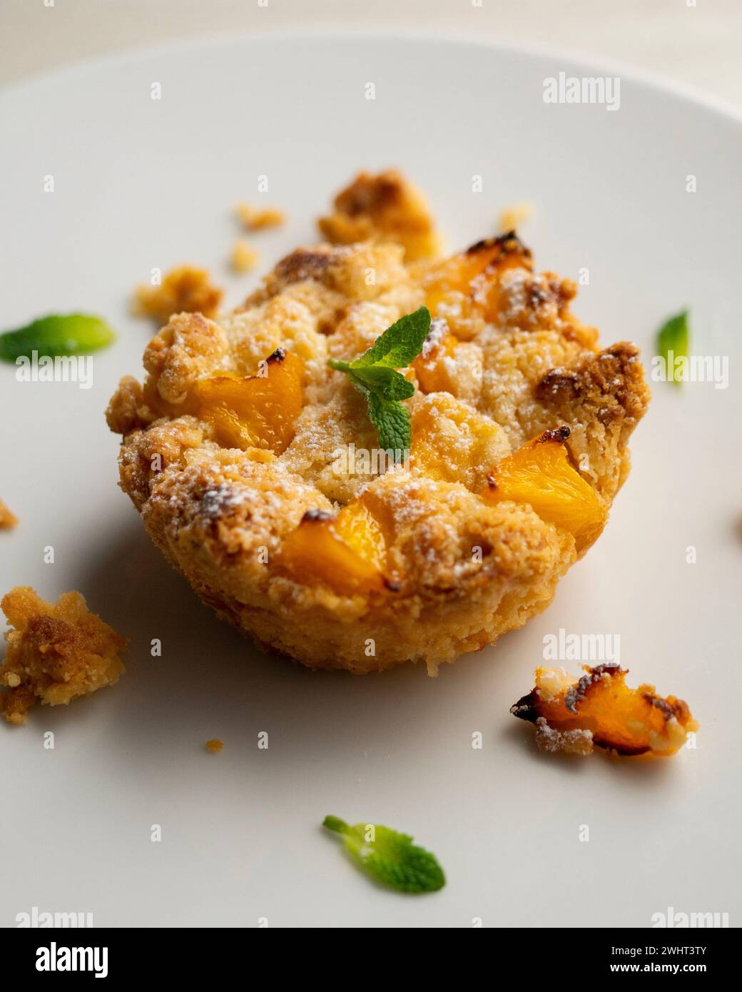 Peach crumble tartlet in a French pastry shop in Paris Stock Photo - Alamy