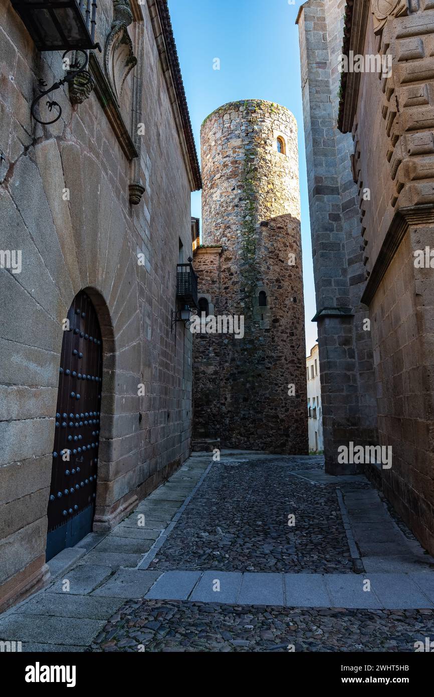 Medieval buildings with large wooden doors and stone towers in Caceres ...