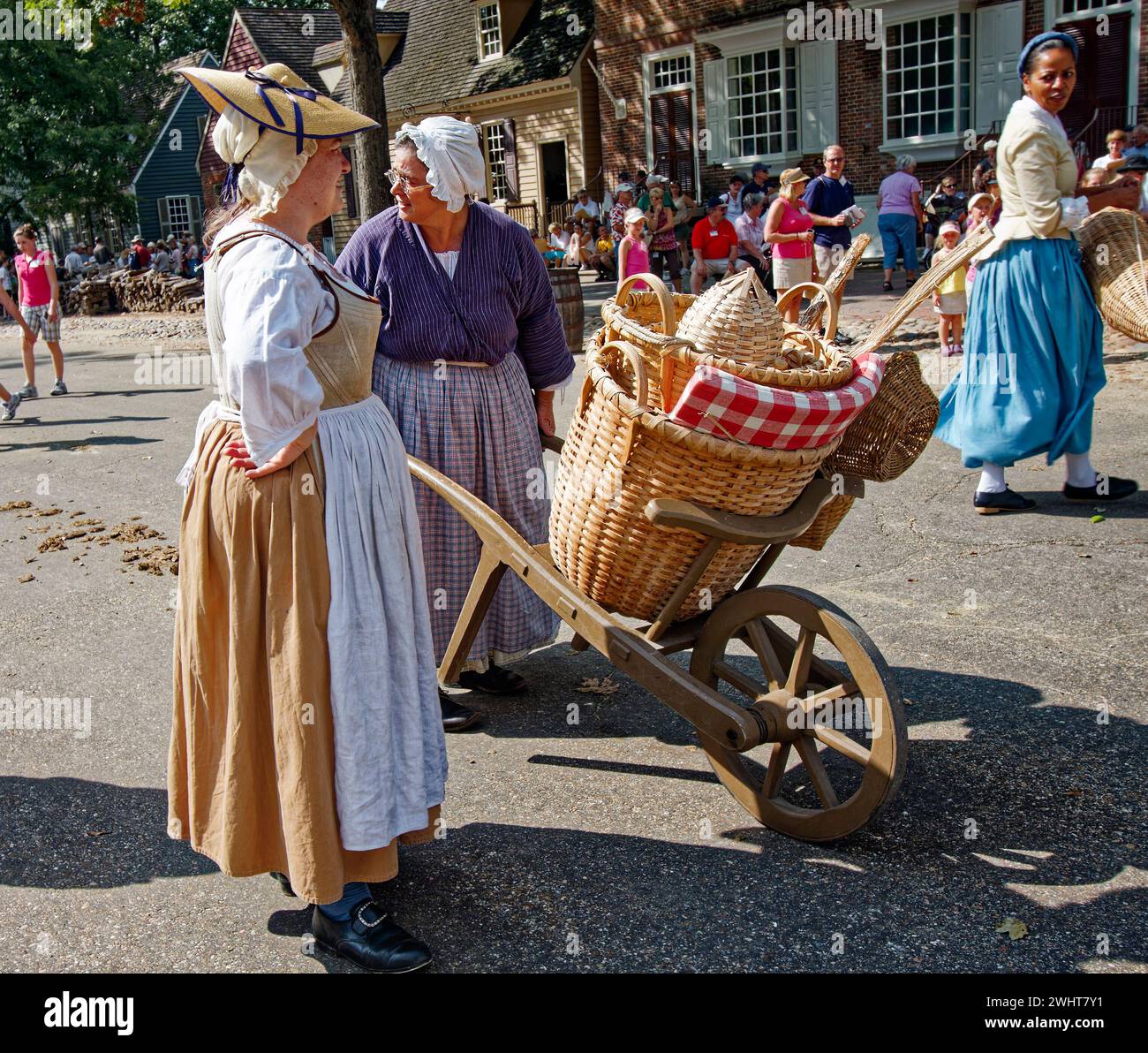 historic interpreters, dressed in colonial garb, women, pushing cart ...