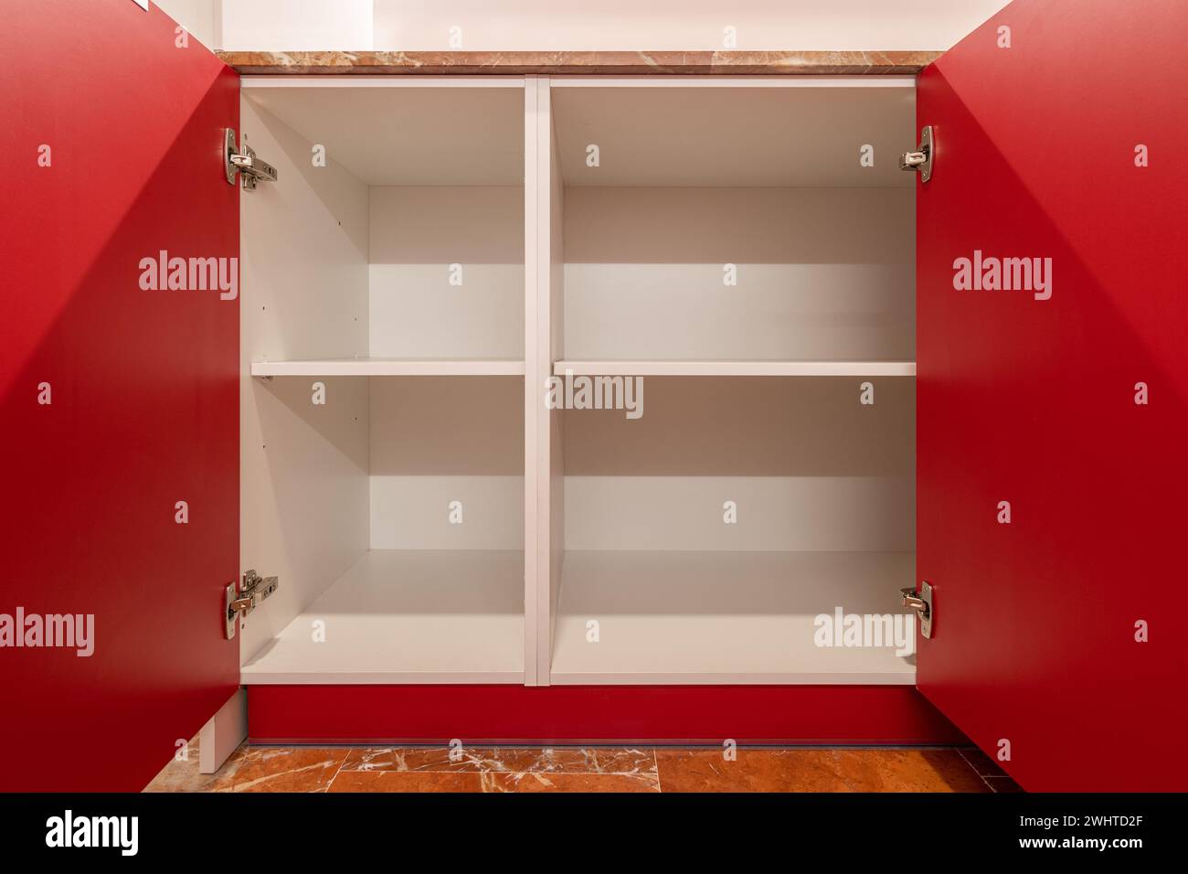 Bright red open cupboard with empty white shelves and a terracotta ...