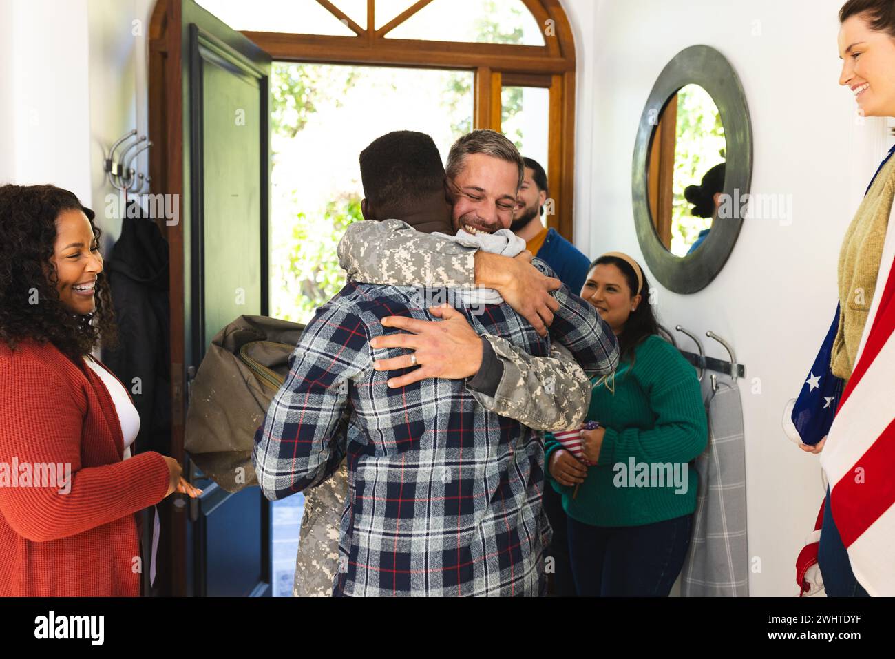 Happy diverse friends with flags welcoming home male soldier friend ...