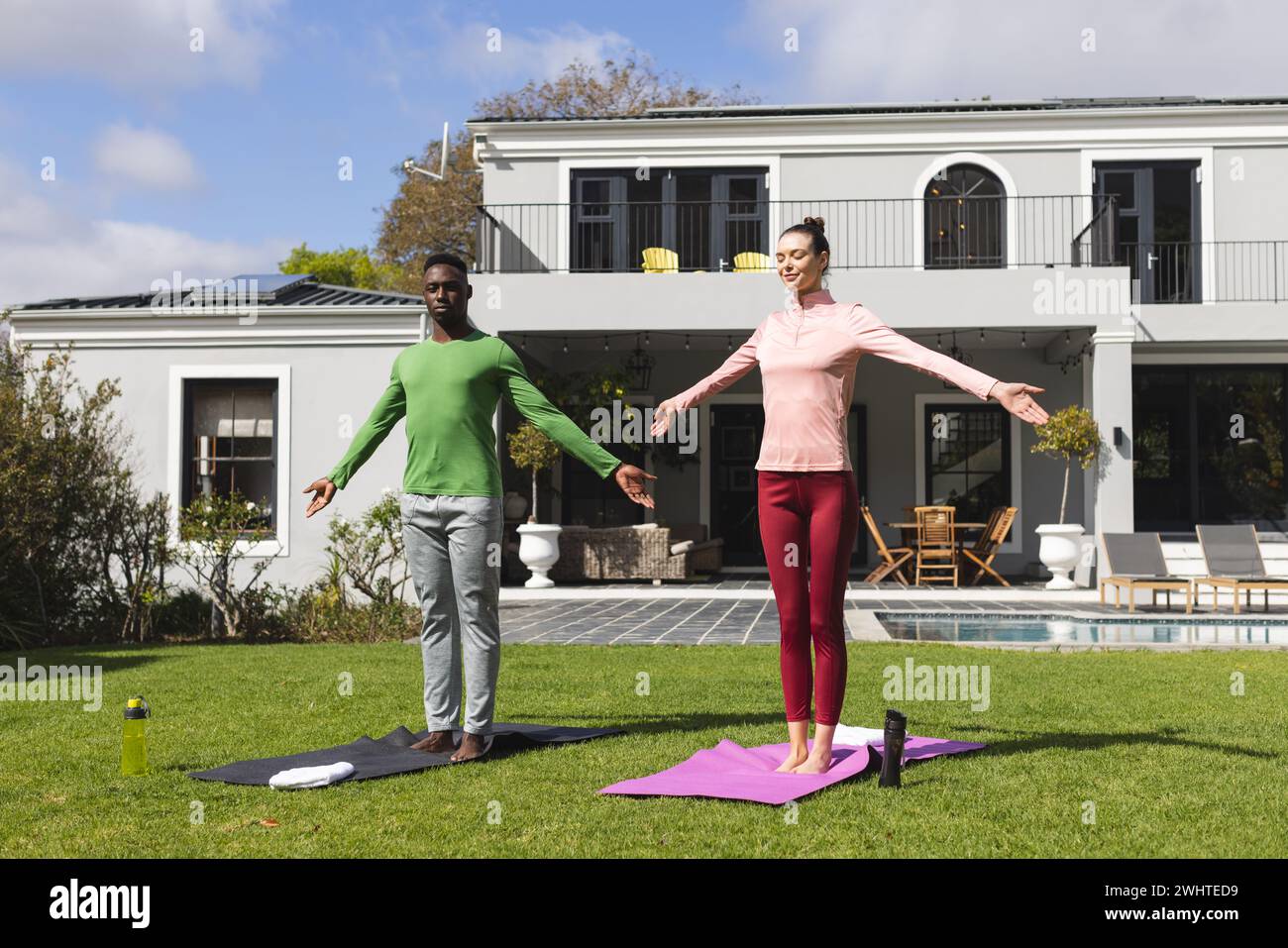 Diverse couple practicing yoga and stretching in garden Stock Photo - Alamy