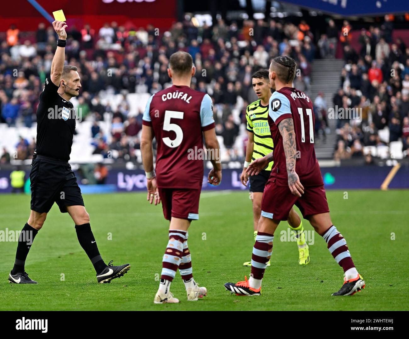 London, UK. 11th Feb, 2024. Craig Pawson (Referee) shows the yellow card to Kalvin Phillips ...