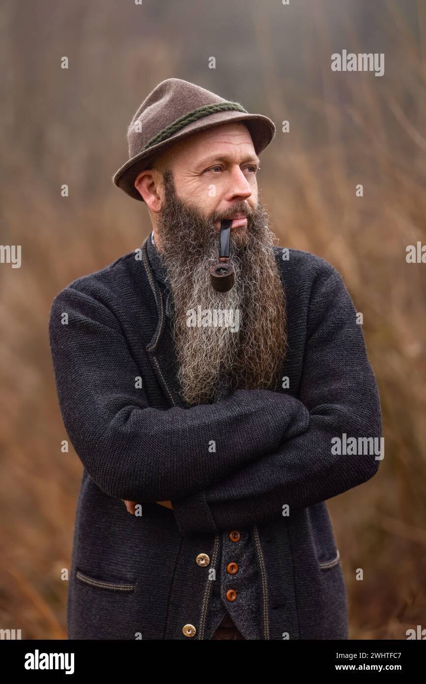Portrait of a typical bavarian man smoking a pipe and wearing a ...
