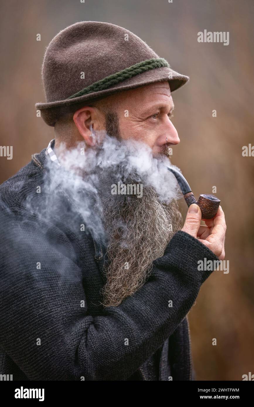 Portrait of a typical bavarian man smoking a pipe and wearing a ...