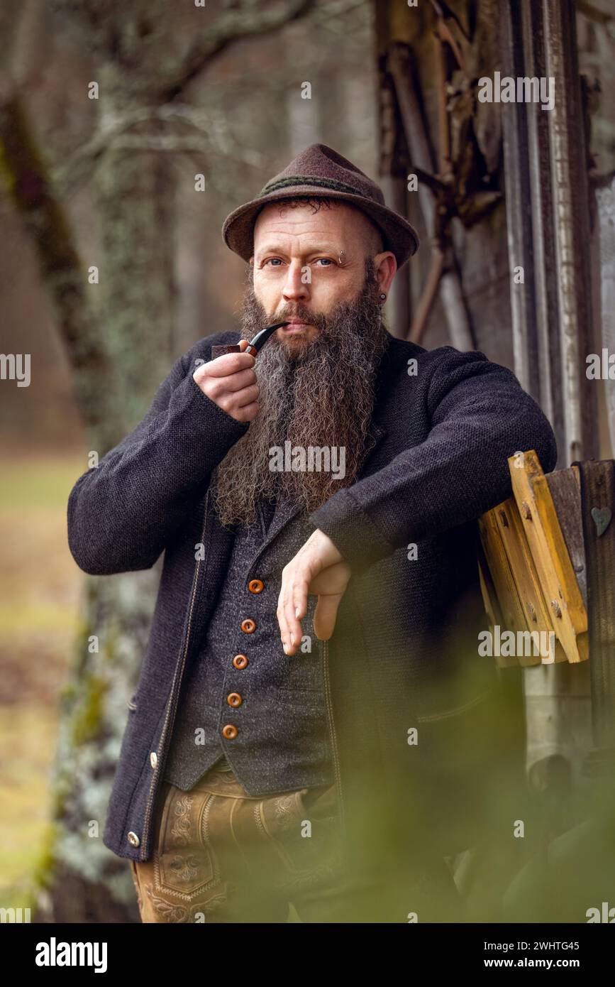 Portrait of a typical bavarian man smoking a pipe and wearing a ...