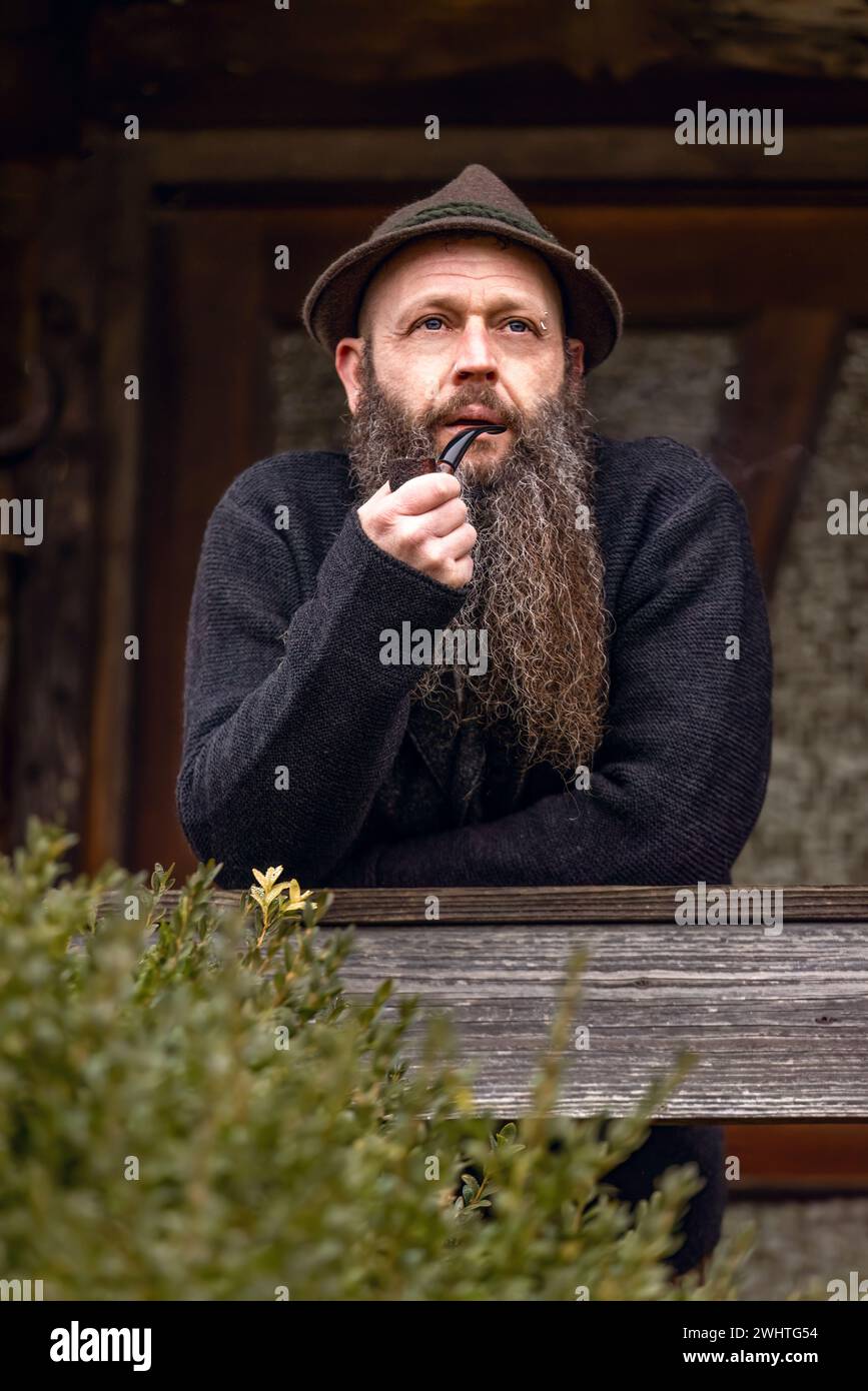 Portrait of a typical bavarian man smoking a pipe and wearing a ...