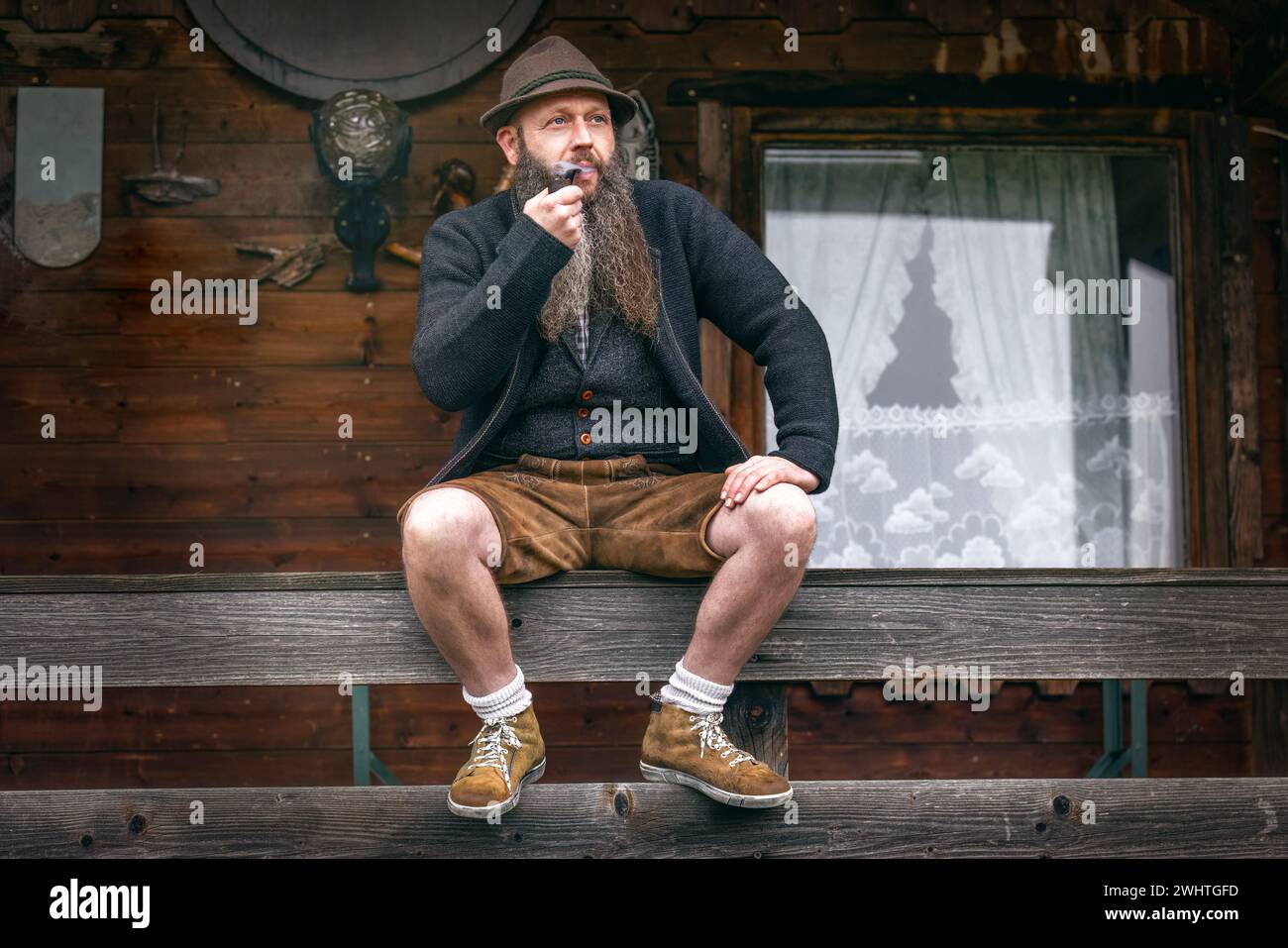 Portrait of a typical bavarian man smoking a pipe and wearing a ...